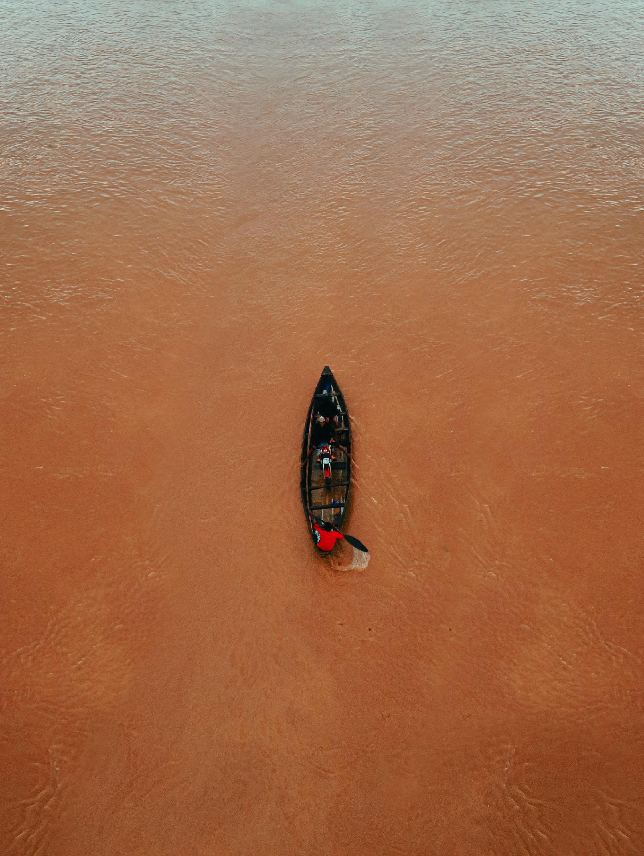 Aerial View of Boat on Rust-Colored River · Free Stock Photo