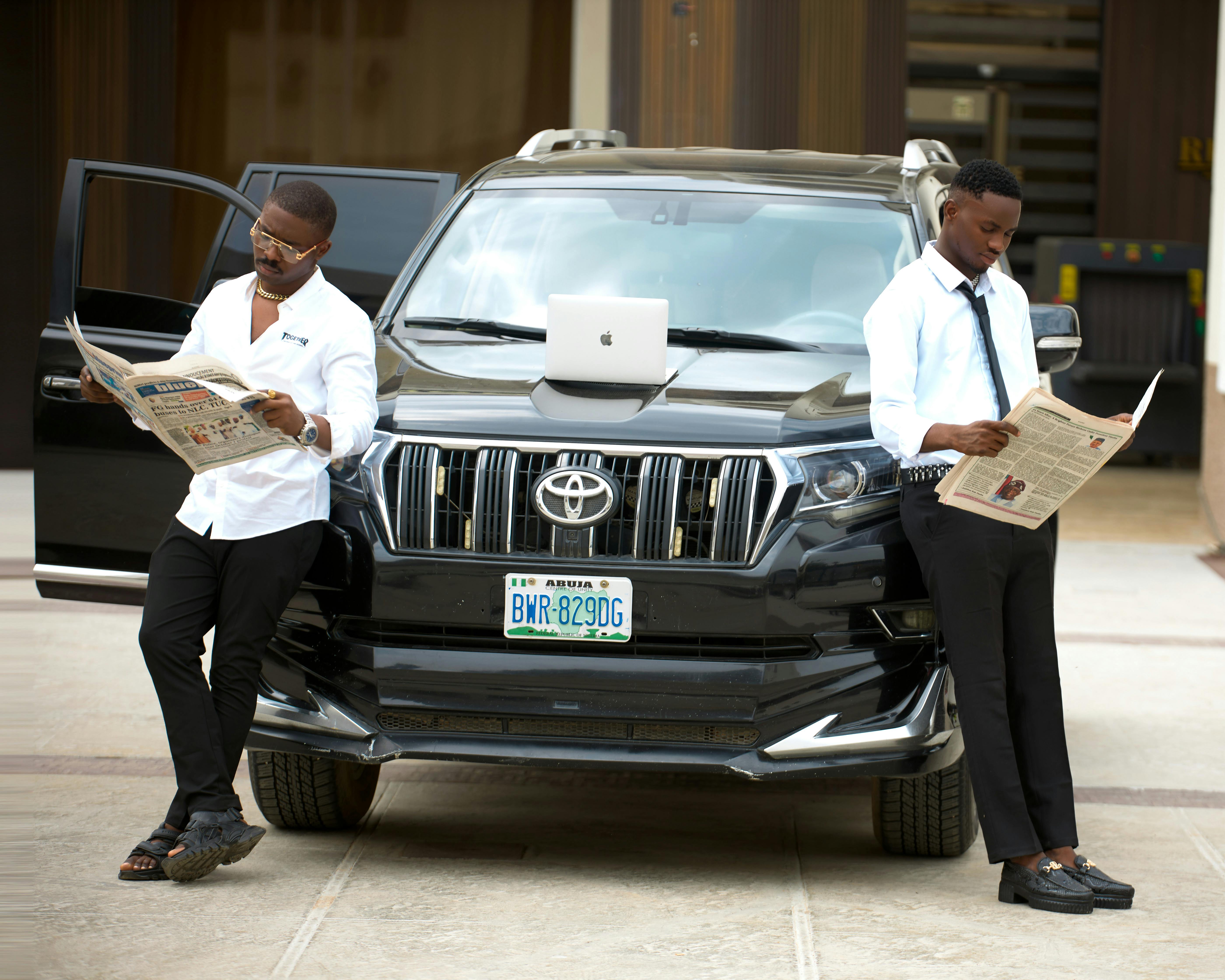 Two Men Reading Newspapers by Luxury SUV · Free Stock Photo