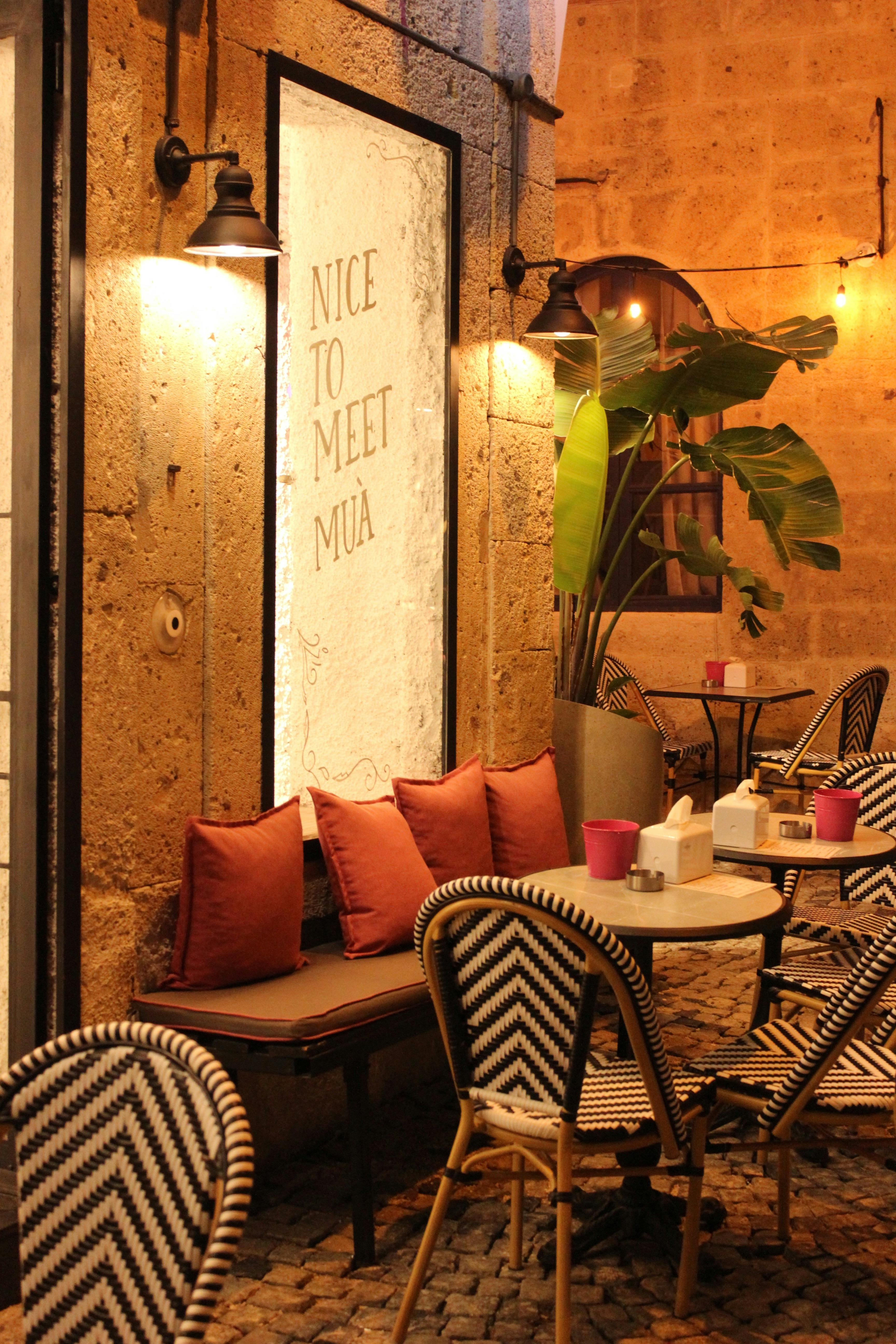 Cozy Outdoor Cafe Seating at Night with Warm Lighting · Free Stock Photo