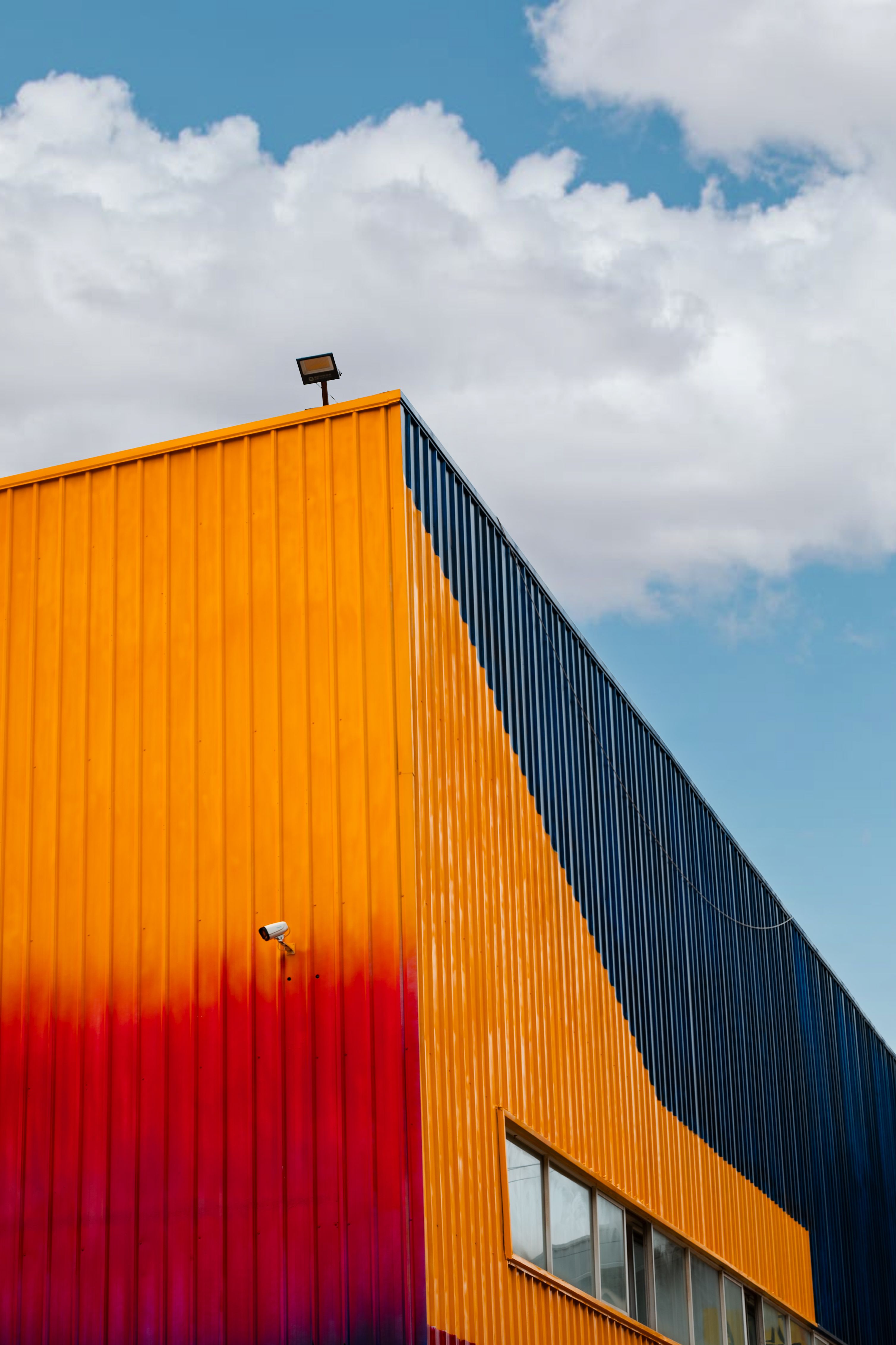 Vibrant Warehouse Exterior Against Blue Sky · Free Stock Photo
