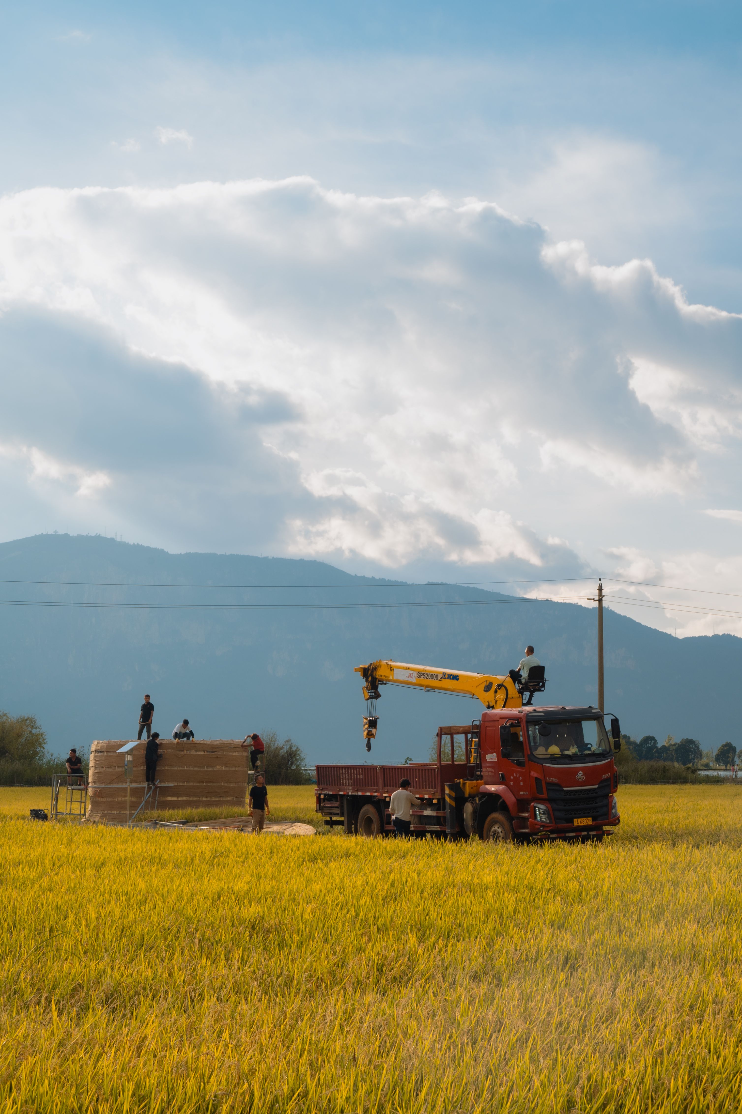 Rural Hay Harvest with Truck and Crane in Field · Free Stock Photo
