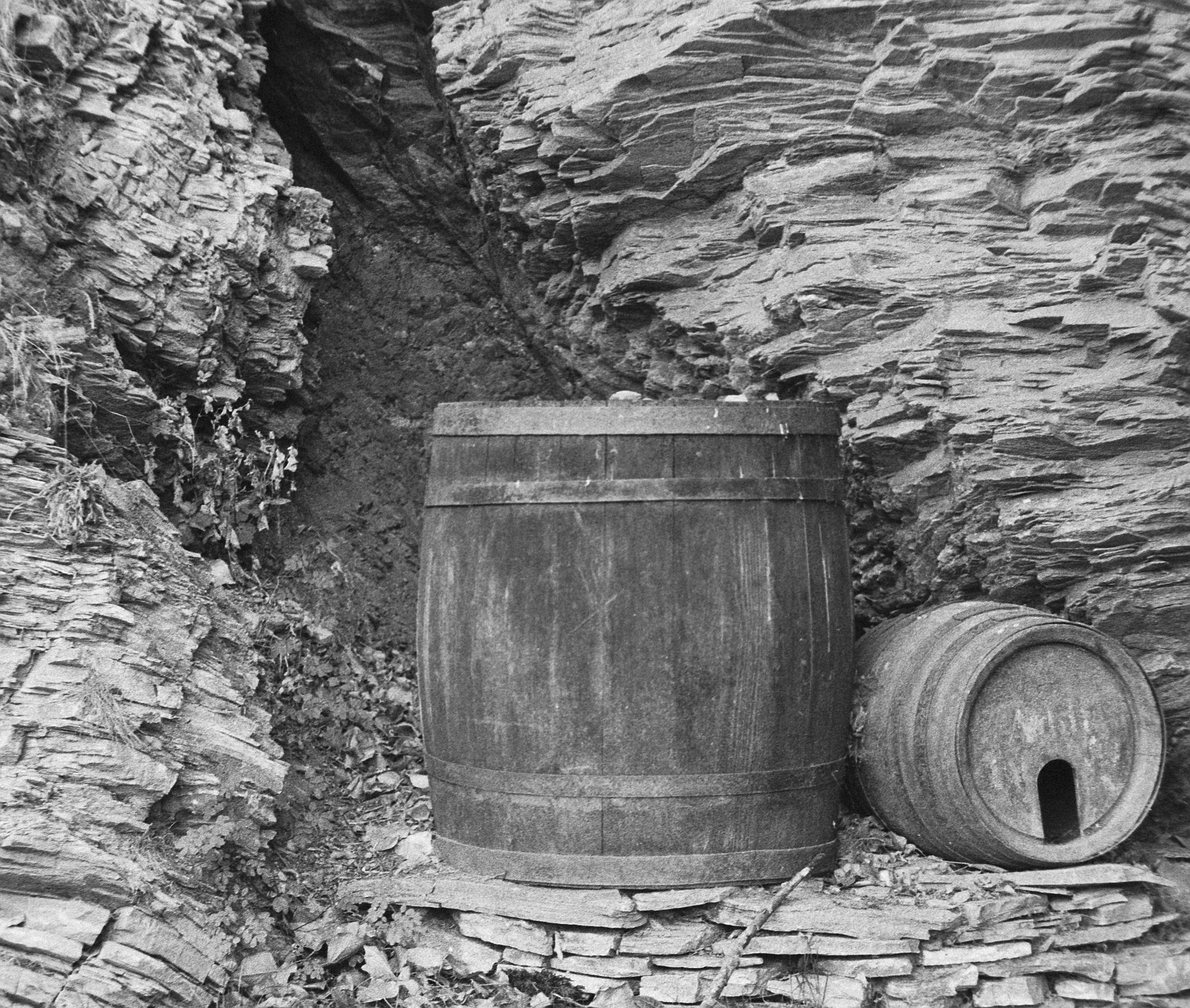 Rustic Wooden Barrels Against Rocky Terrain · Free Stock Photo