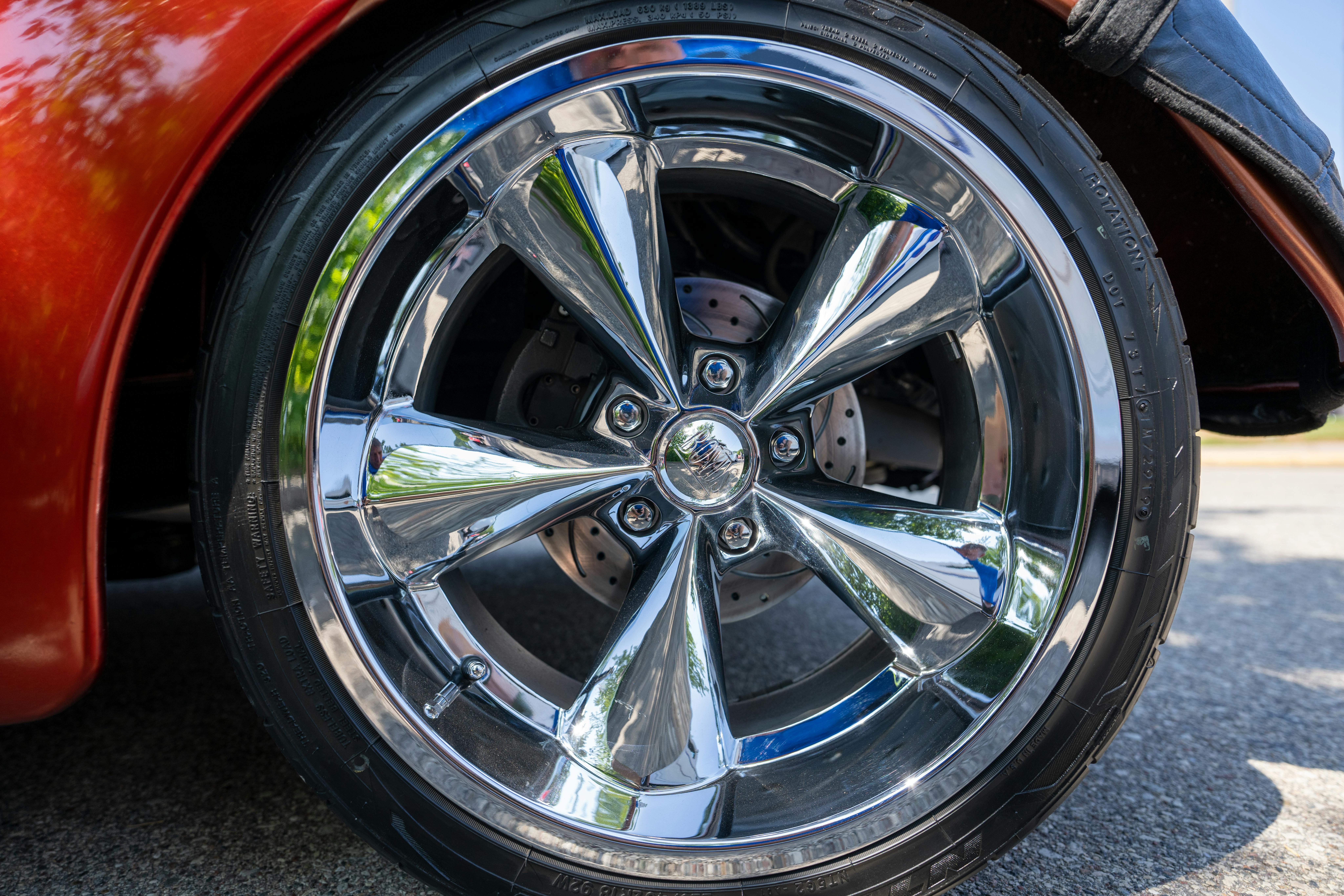 Shiny Chrome Car Wheel on Red Vehicle · Free Stock Photo