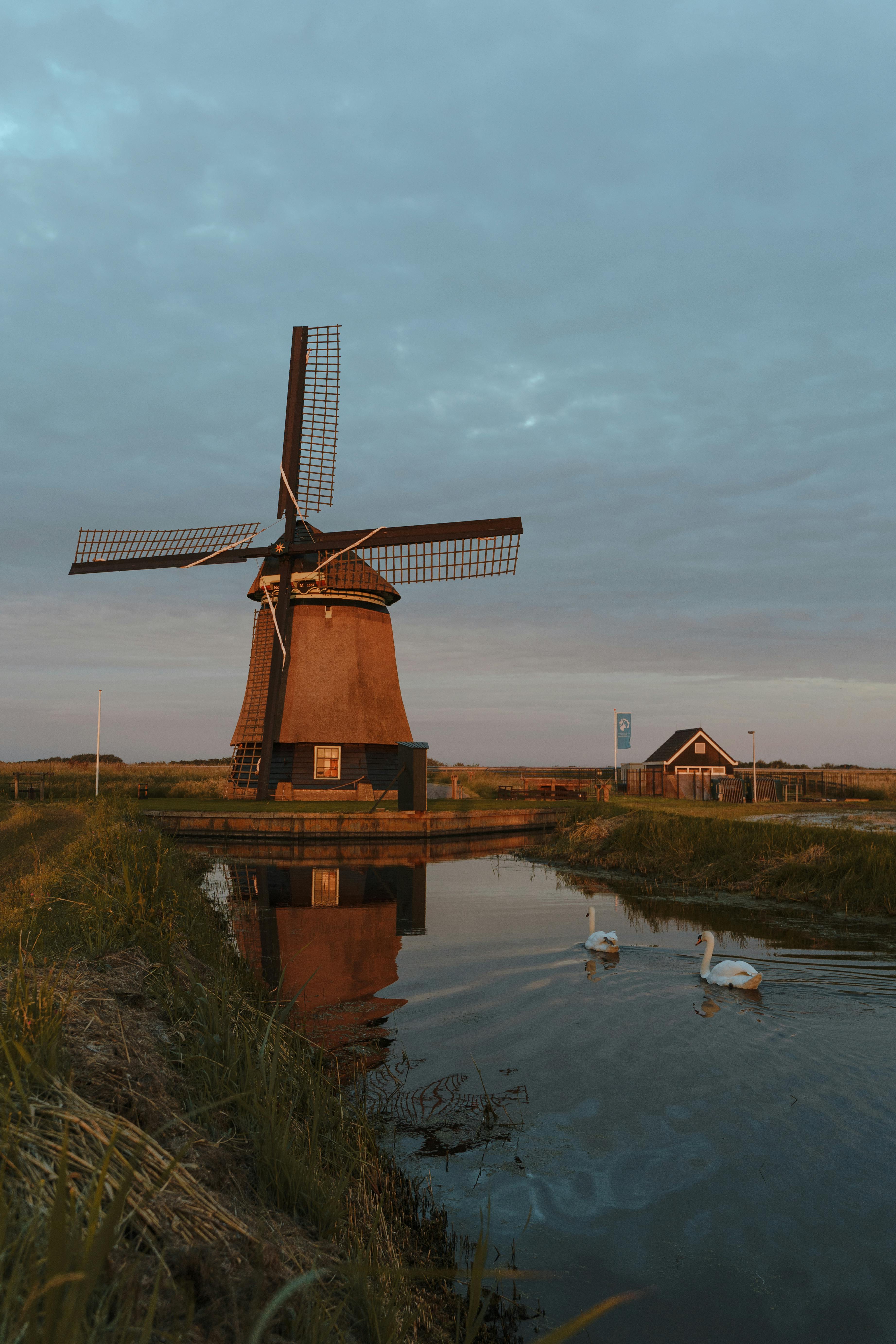 Scenic Windmill by a Reflective Canal at Sunset · Free Stock Photo