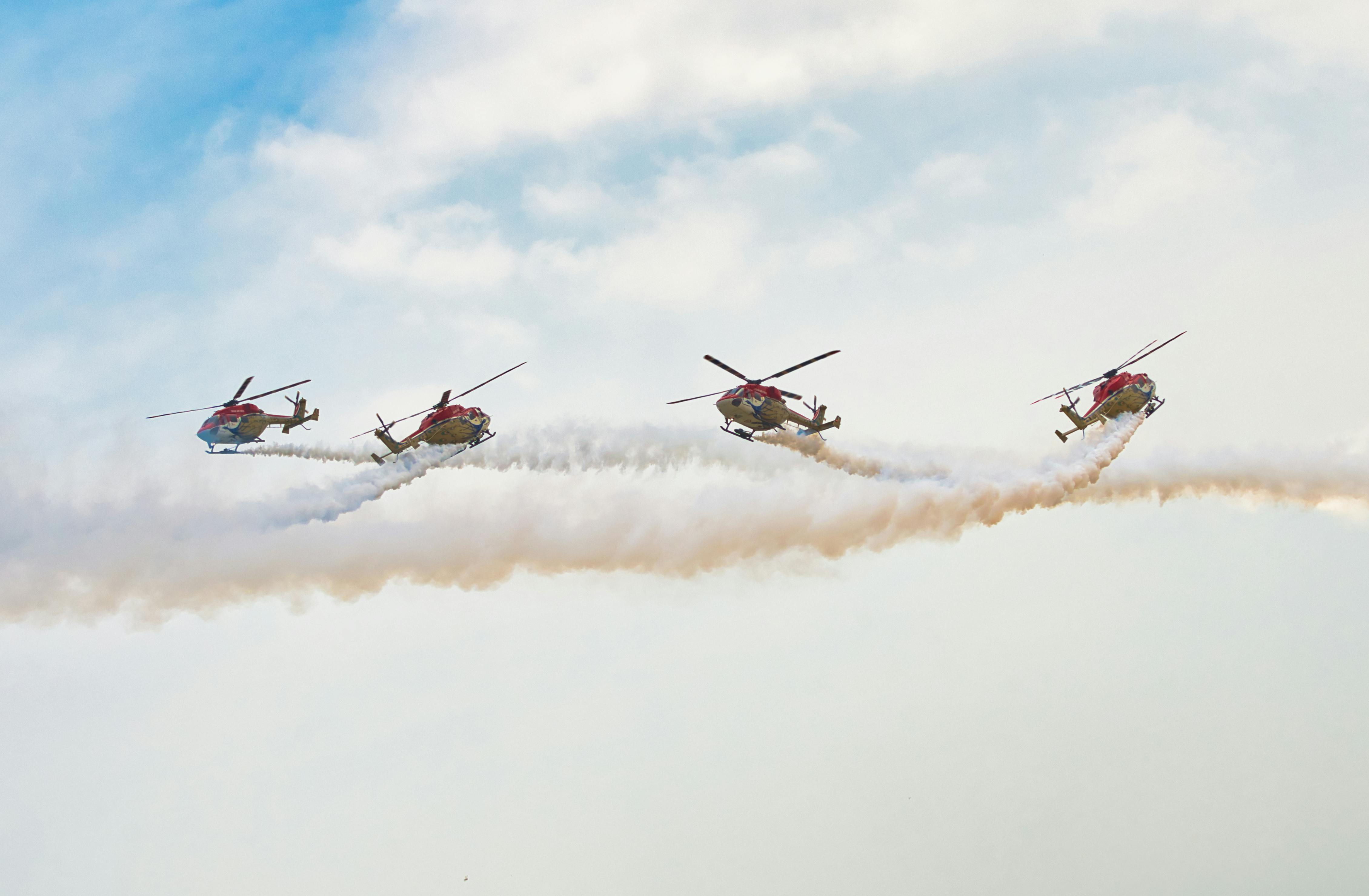 Four helicopters creating aerial smoke display · Free Stock Photo