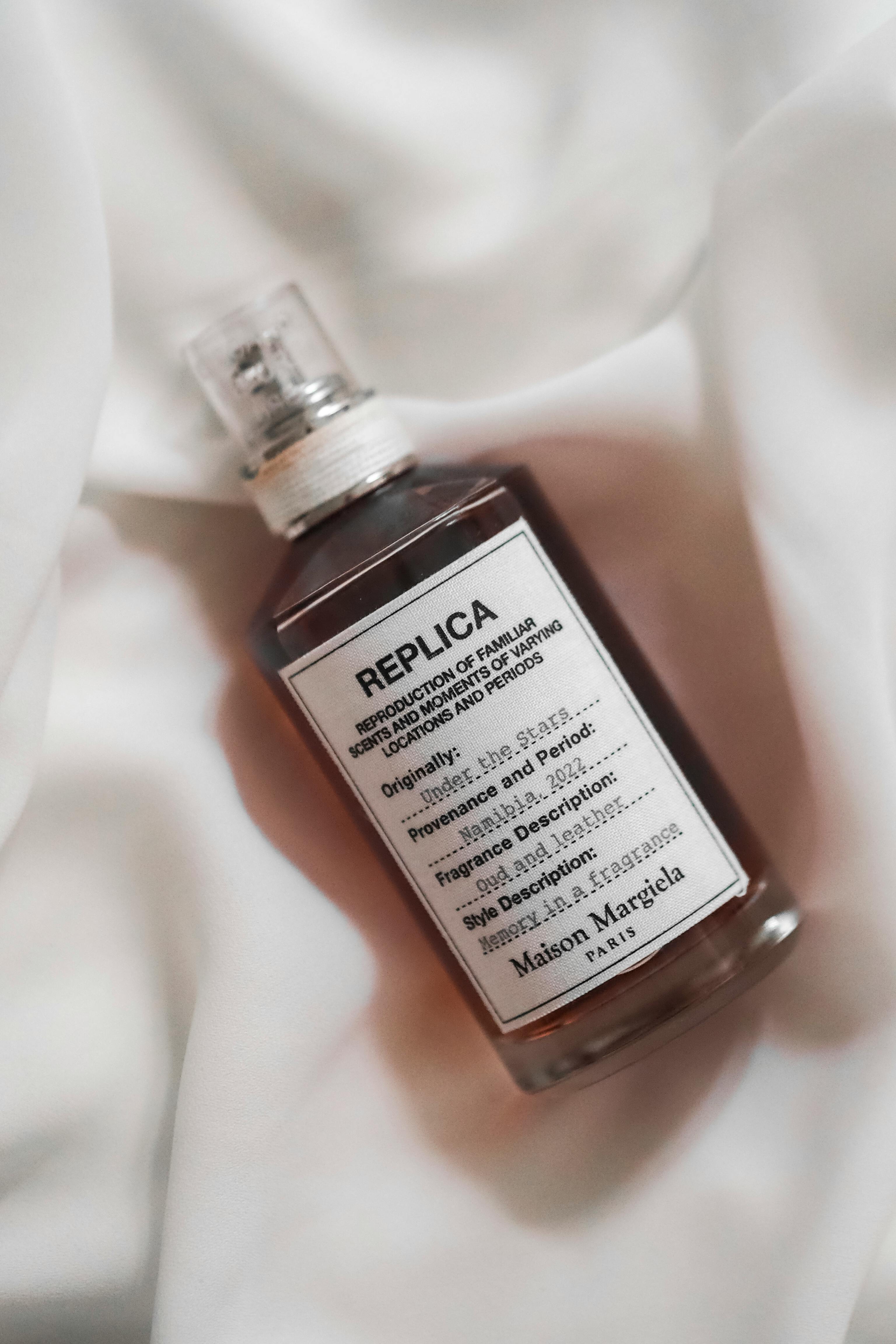 Replica Perfume Bottle on Soft Fabric · Free Stock Photo