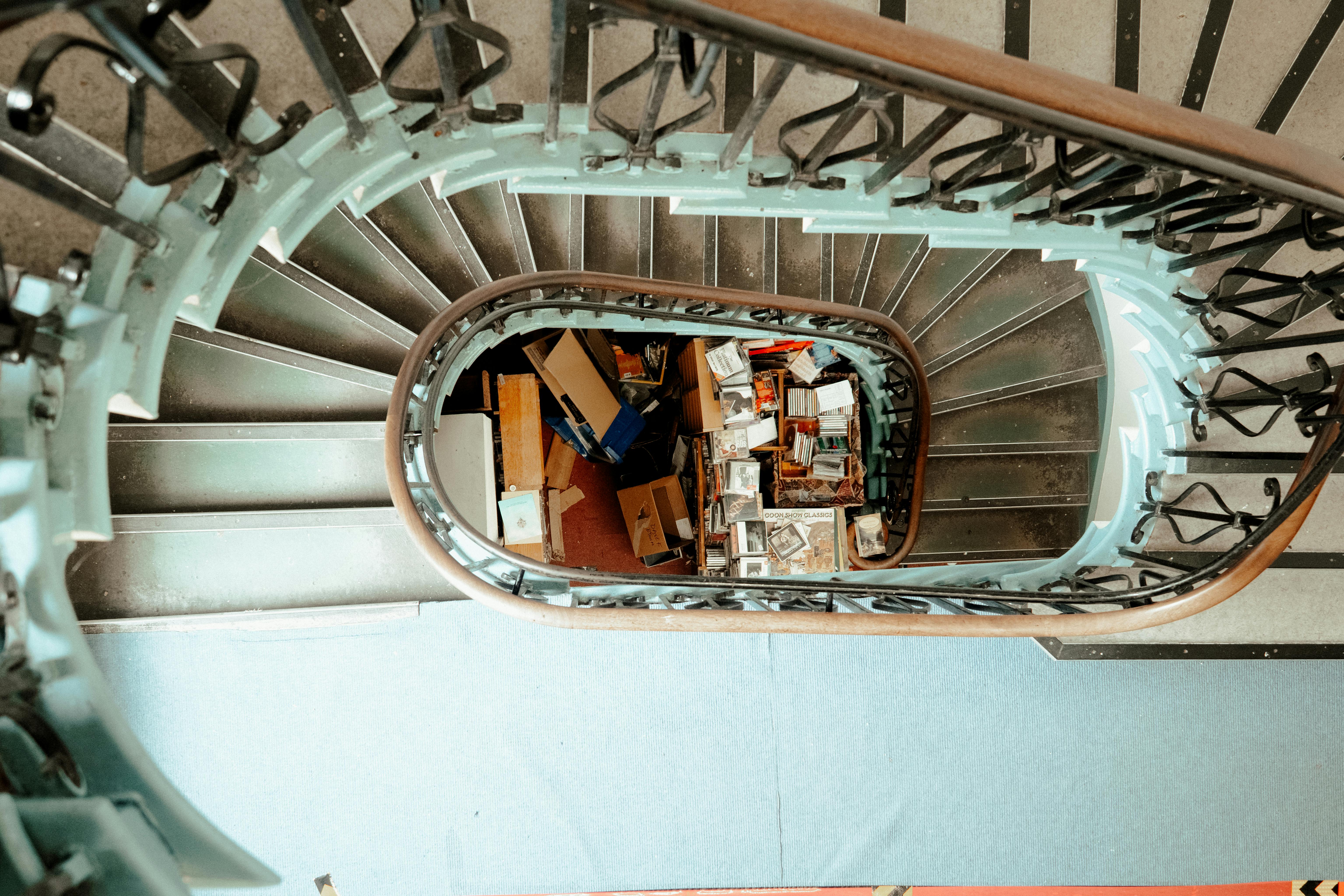 Spiral Staircase Overlooking Busy Storage Area · Free Stock Photo