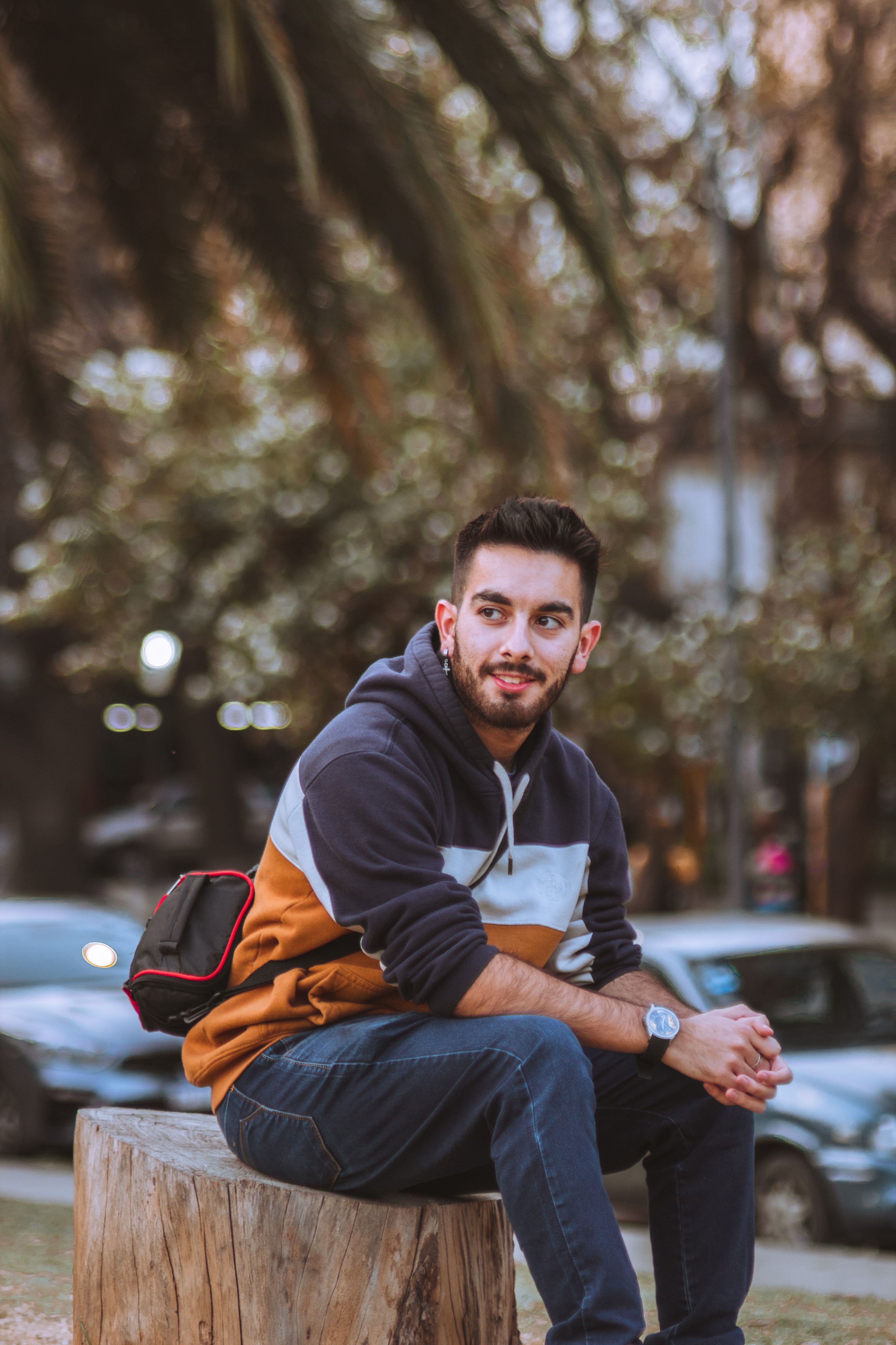 Young Man Sitting Outdoors in Urban Setting · Free Stock Photo