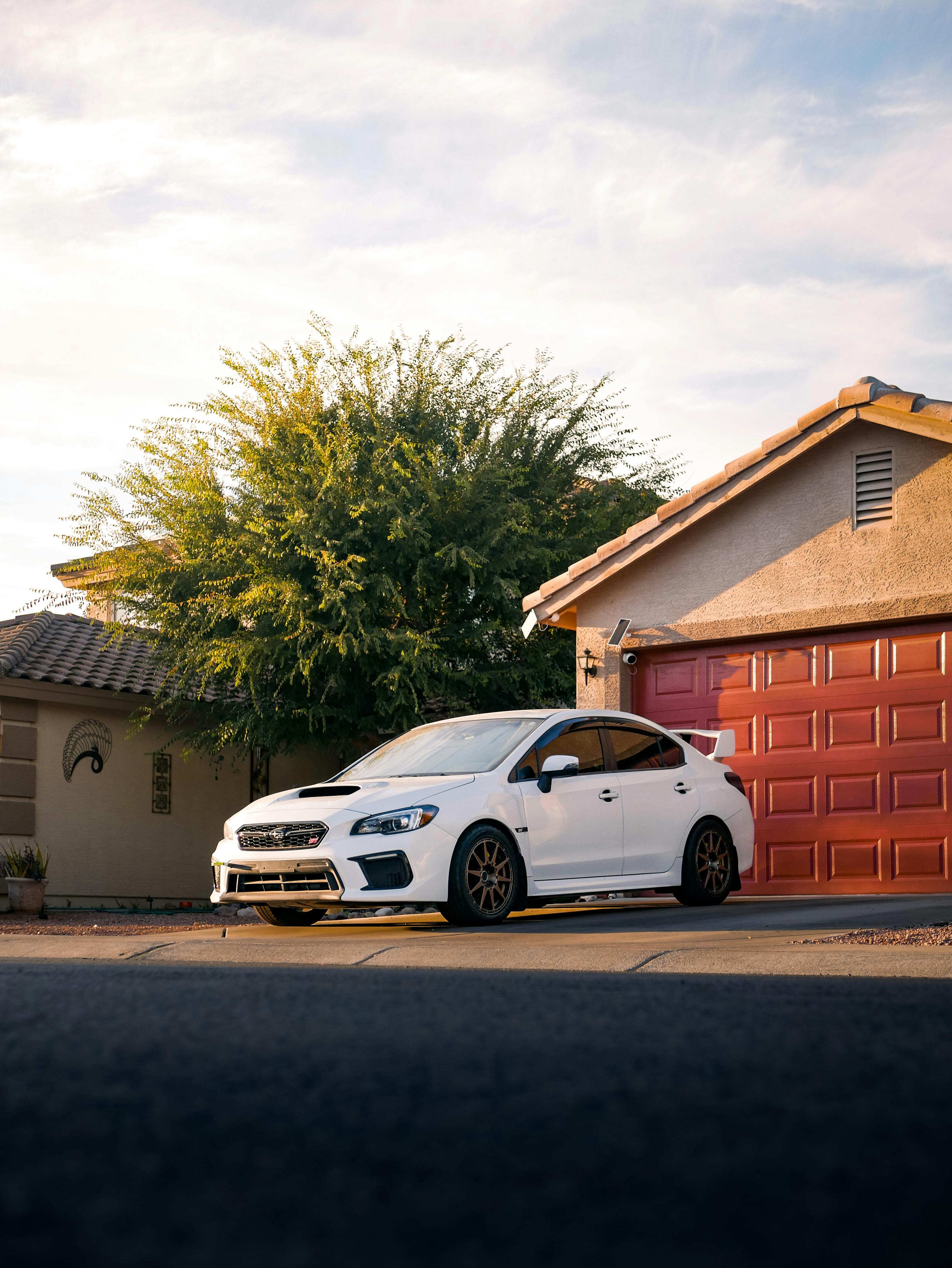 Modern suburban driveway with sleek white car · Free Stock Photo
