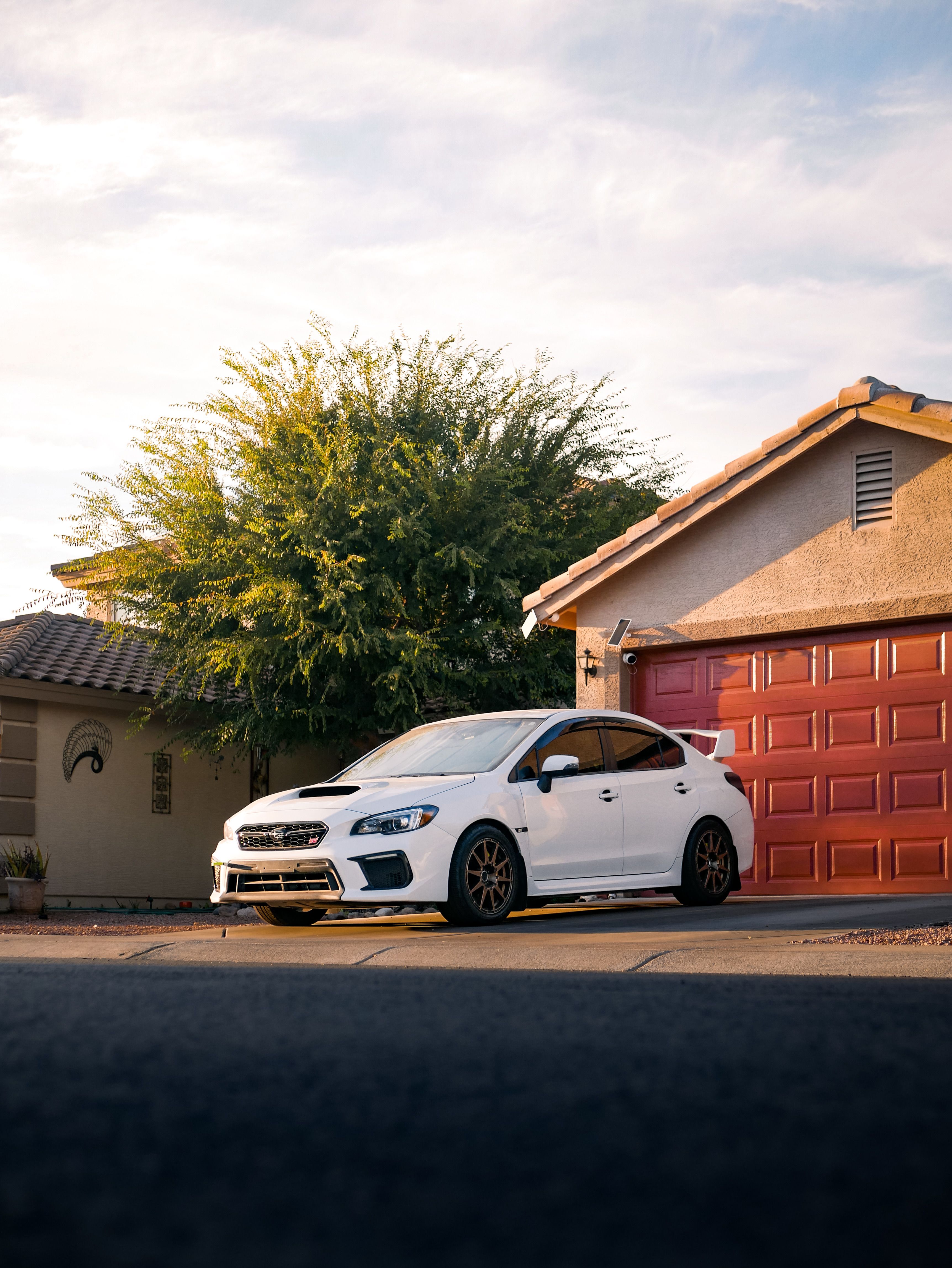 Modern suburban driveway with sleek white car · Free Stock Photo