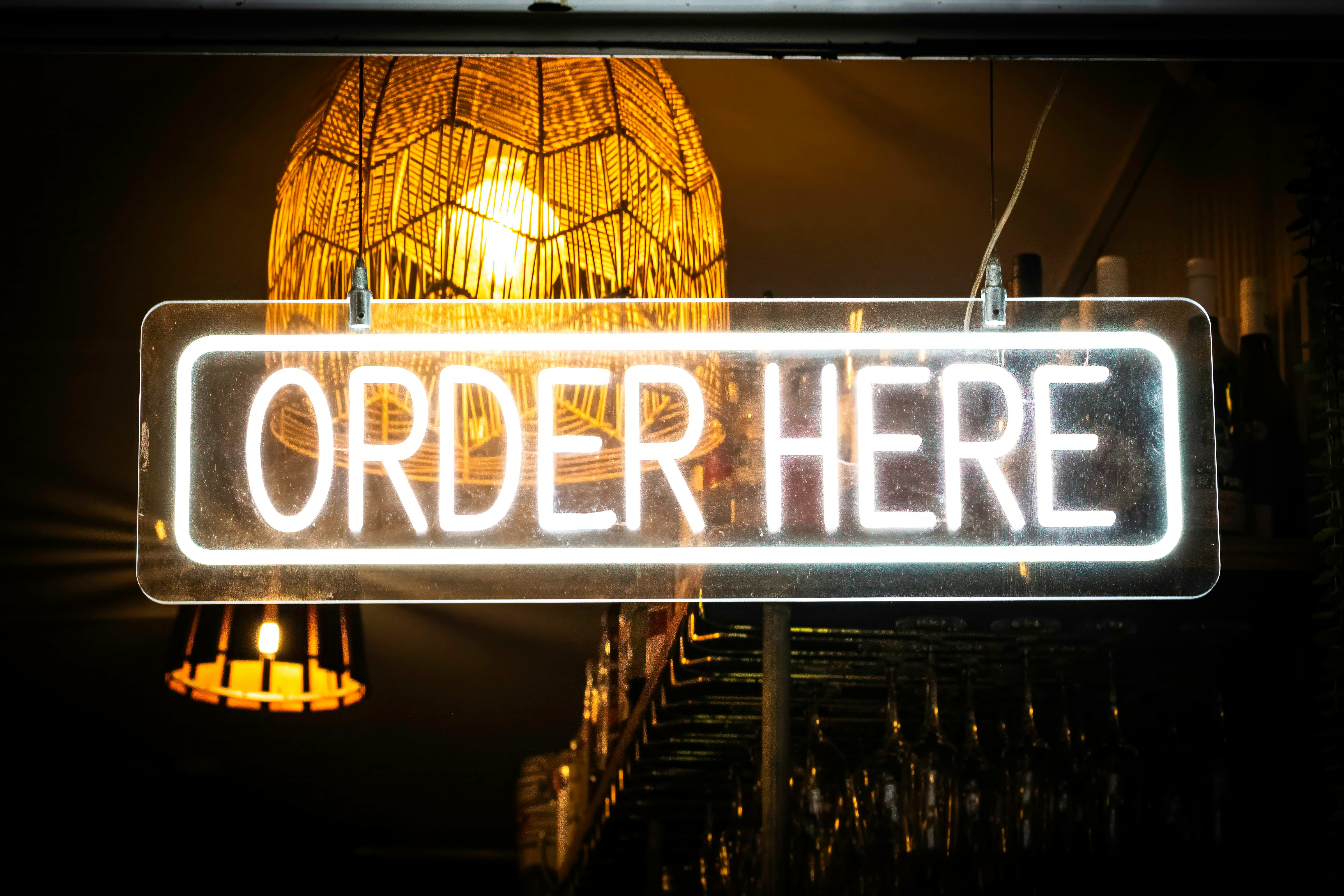 Neon Order Here Sign in Cozy Café Setting · Free Stock Photo