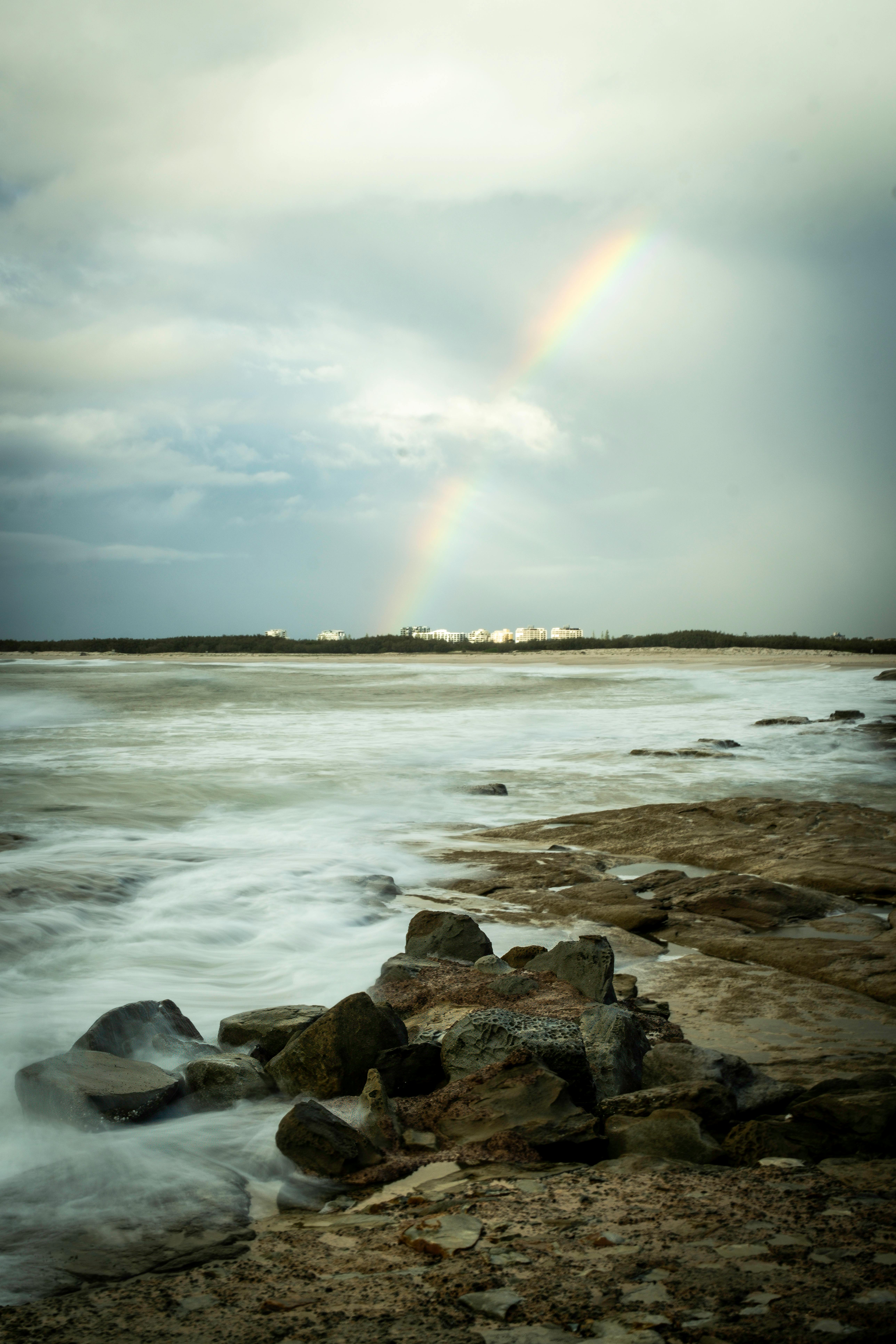 Dramatic Beach Scene with Rainbow Over Ocean · Free Stock Photo