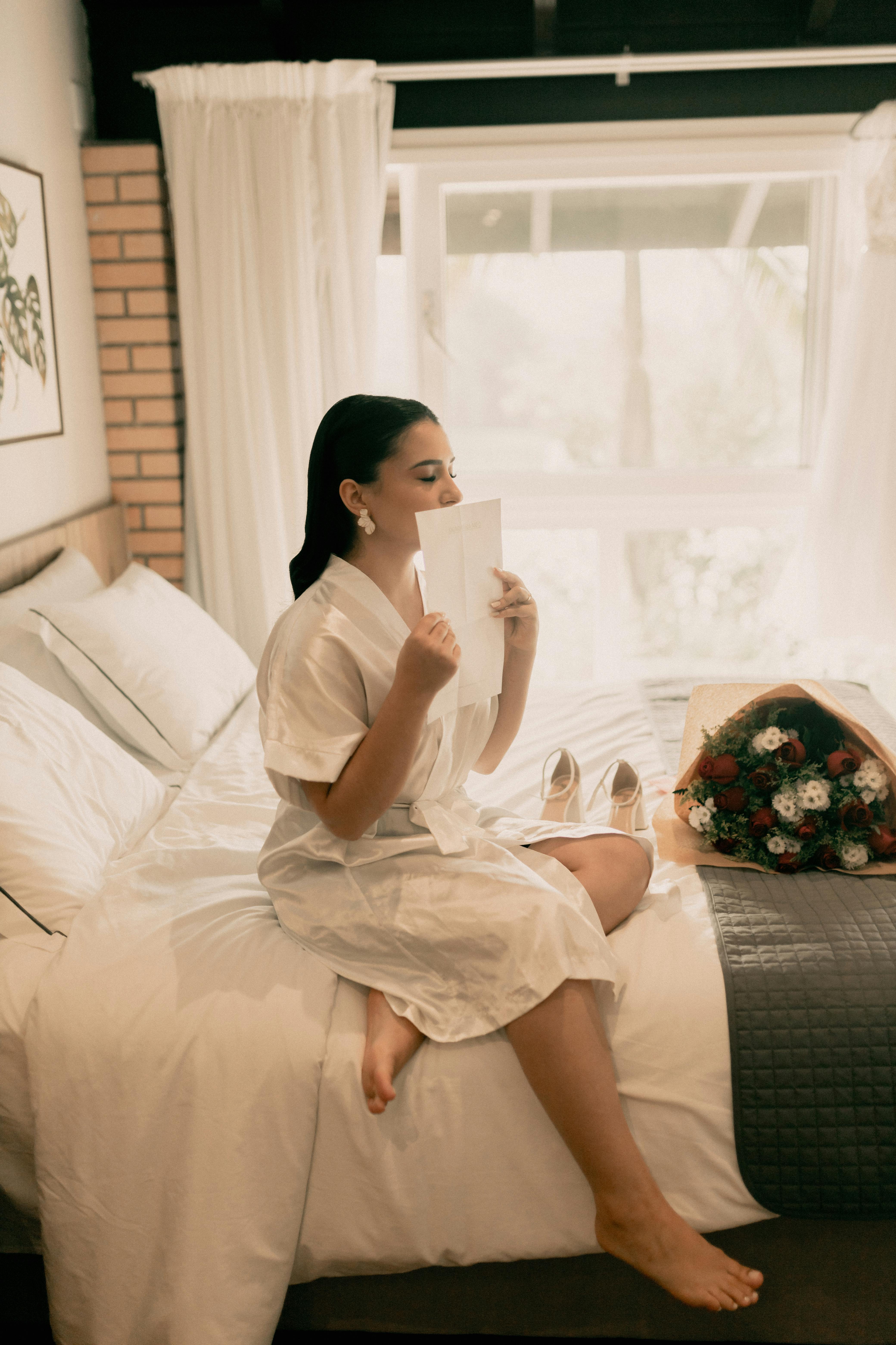 Contemplative Woman Reading Letter on Bed · Free Stock Photo