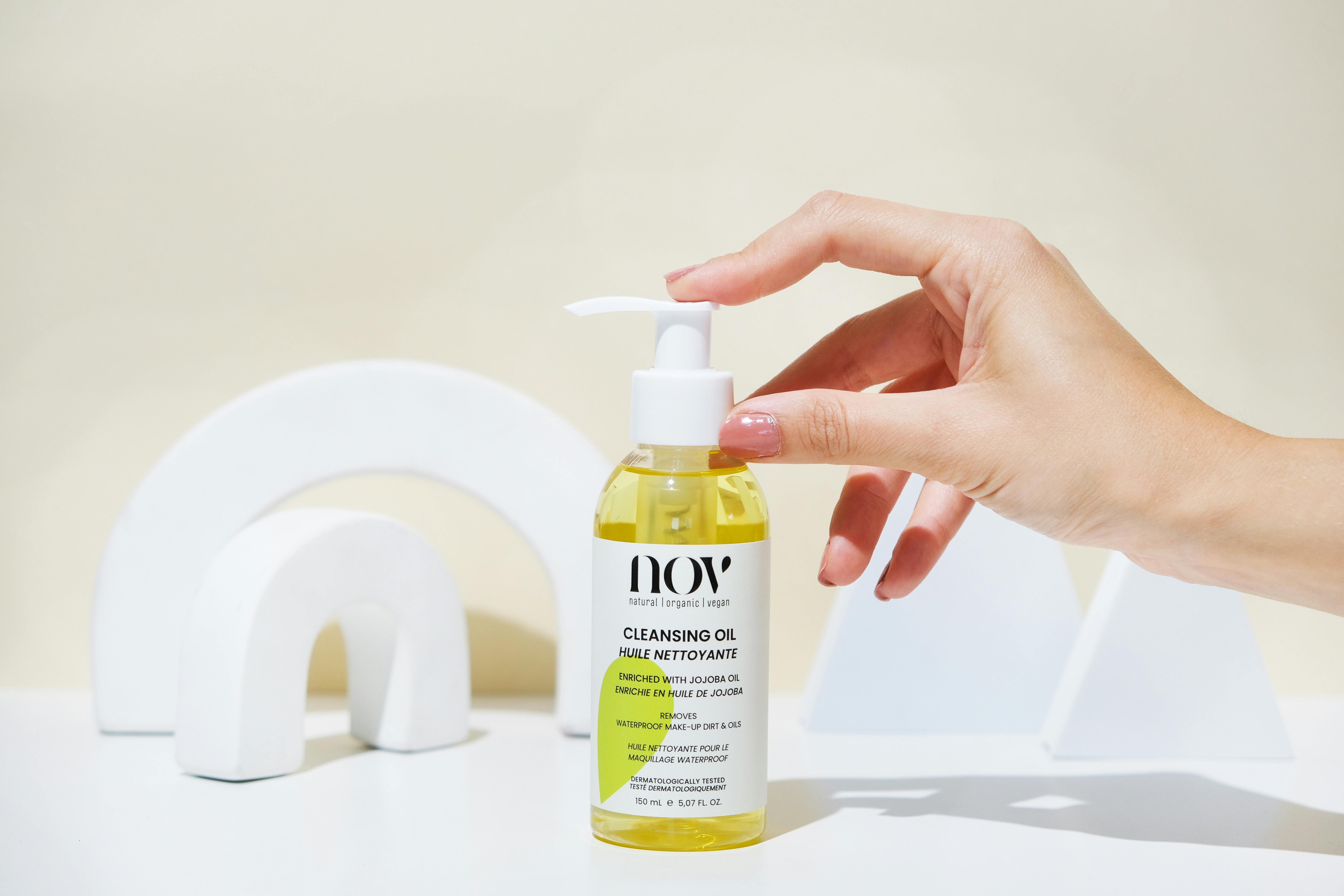 Hand Holding Cleansing Oil Bottle with Modern Decor · Free Stock Photo