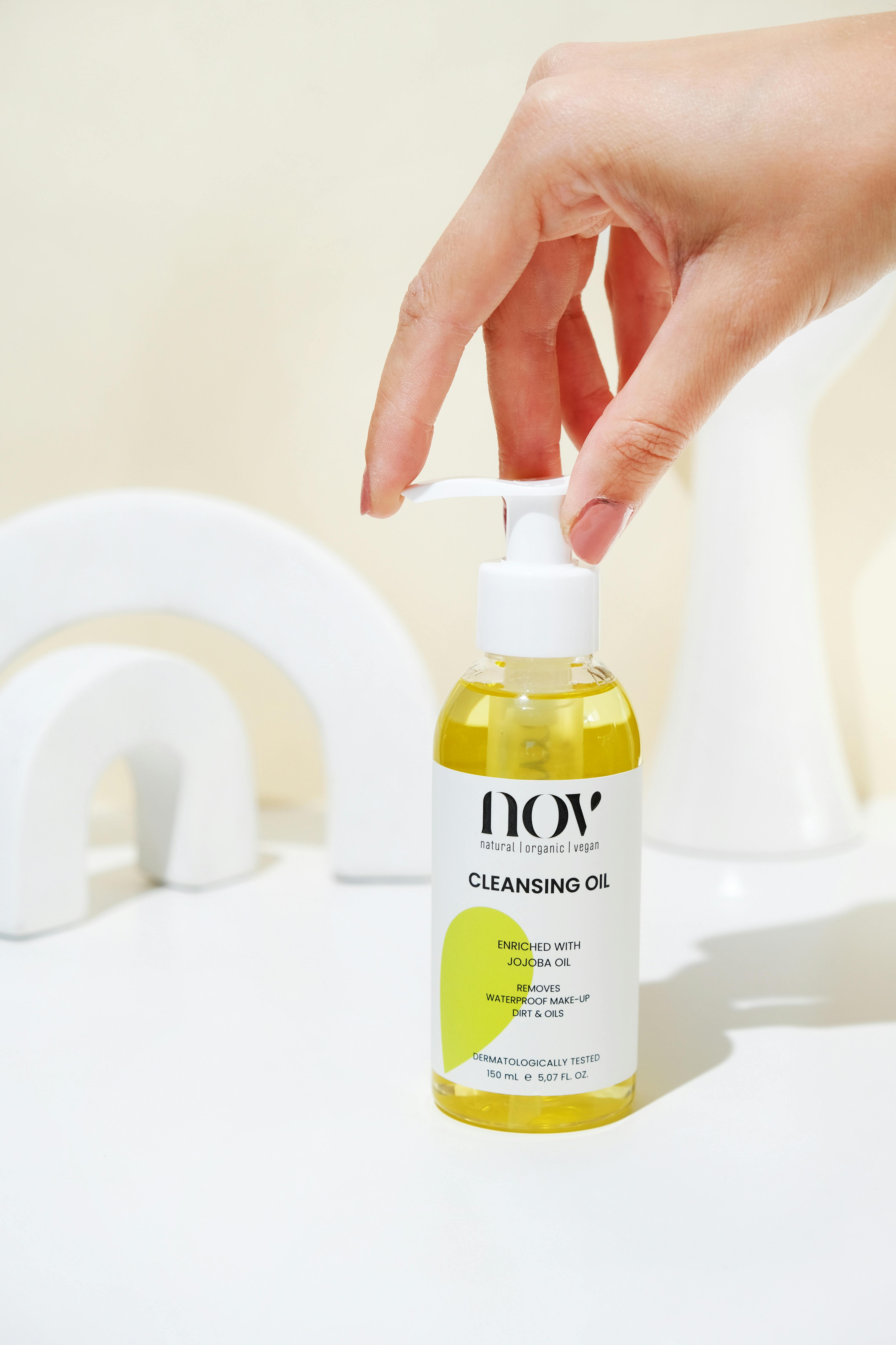 Hand Holding Cleansing Oil Dispenser in Minimalist Setting · Free Stock ...