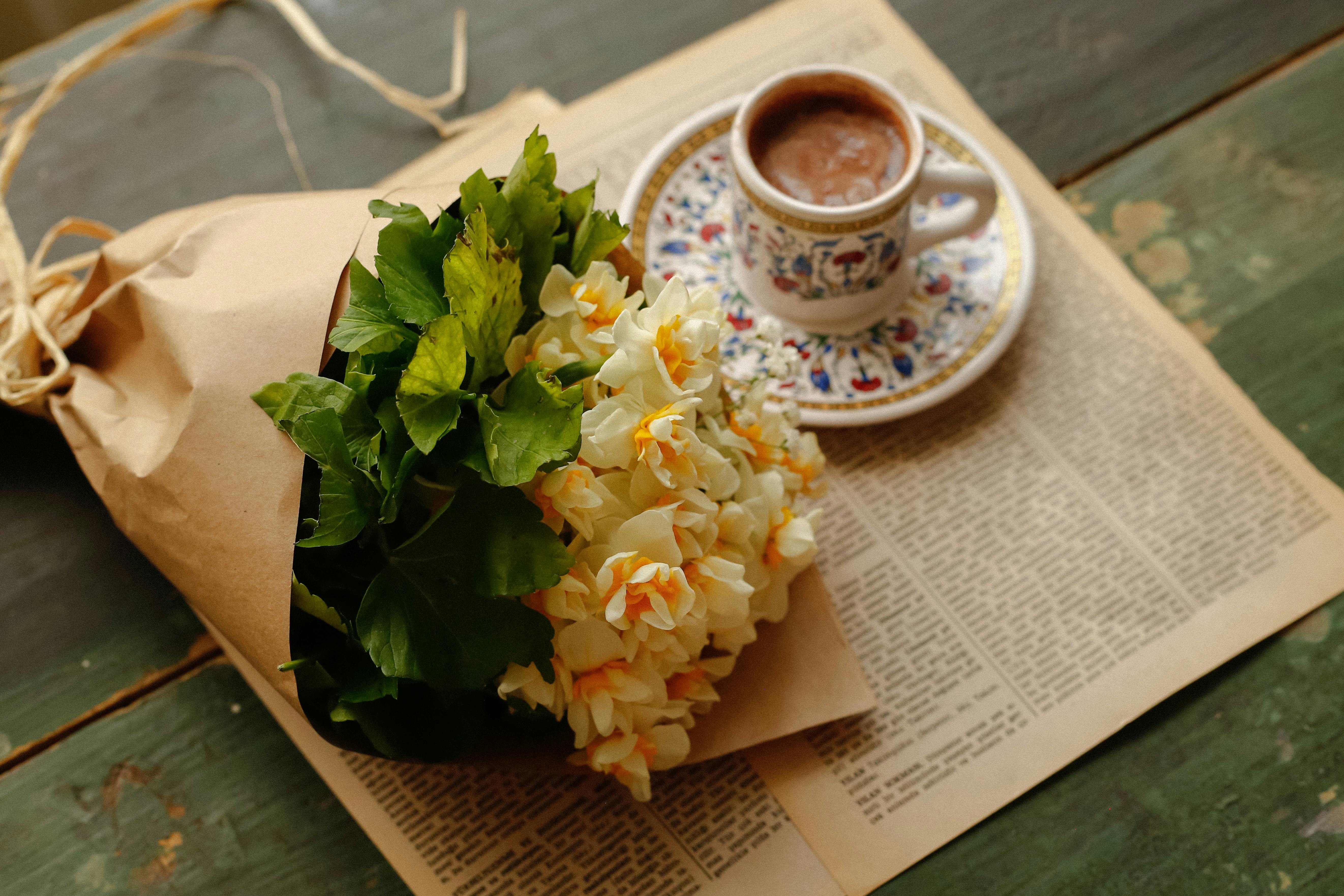 Bouquet and Coffee on Vintage Newspaper Setting · Free Stock Photo