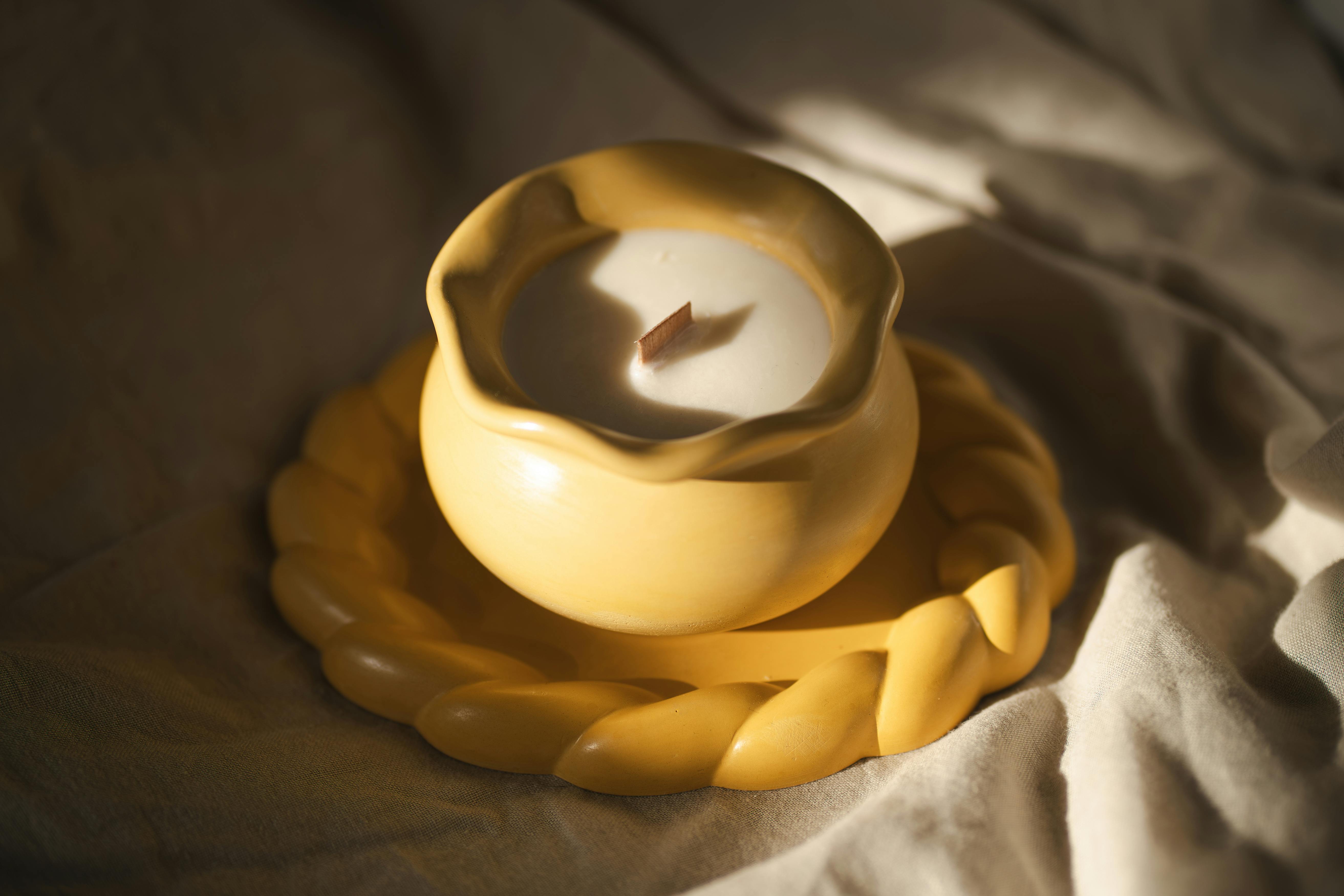 Bohemian Yellow Candle on Woven Plate in Warm Light · Free Stock Photo