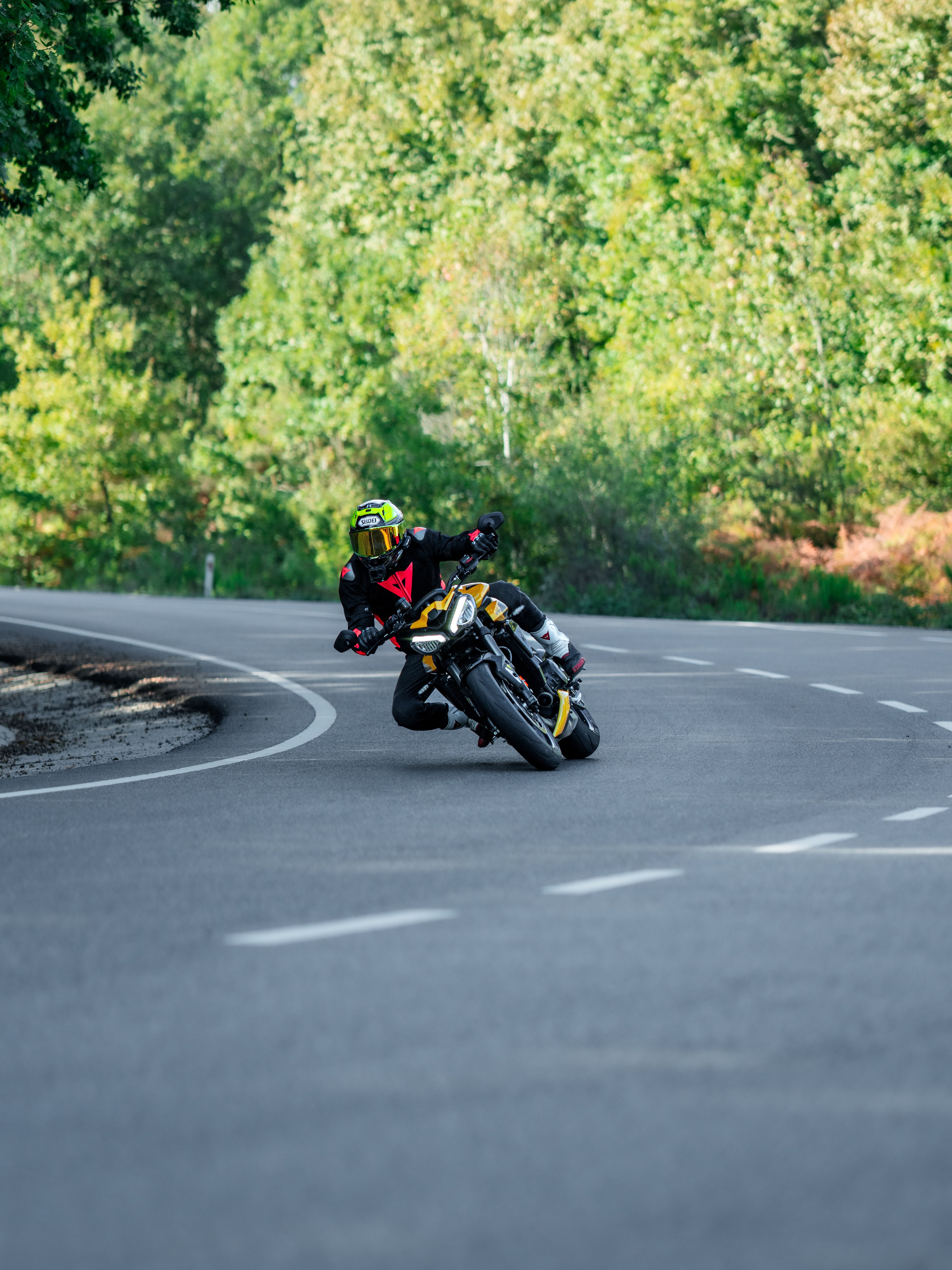Motorcyclist Taking a Sharp Turn on a Curved Road · Free Stock Photo