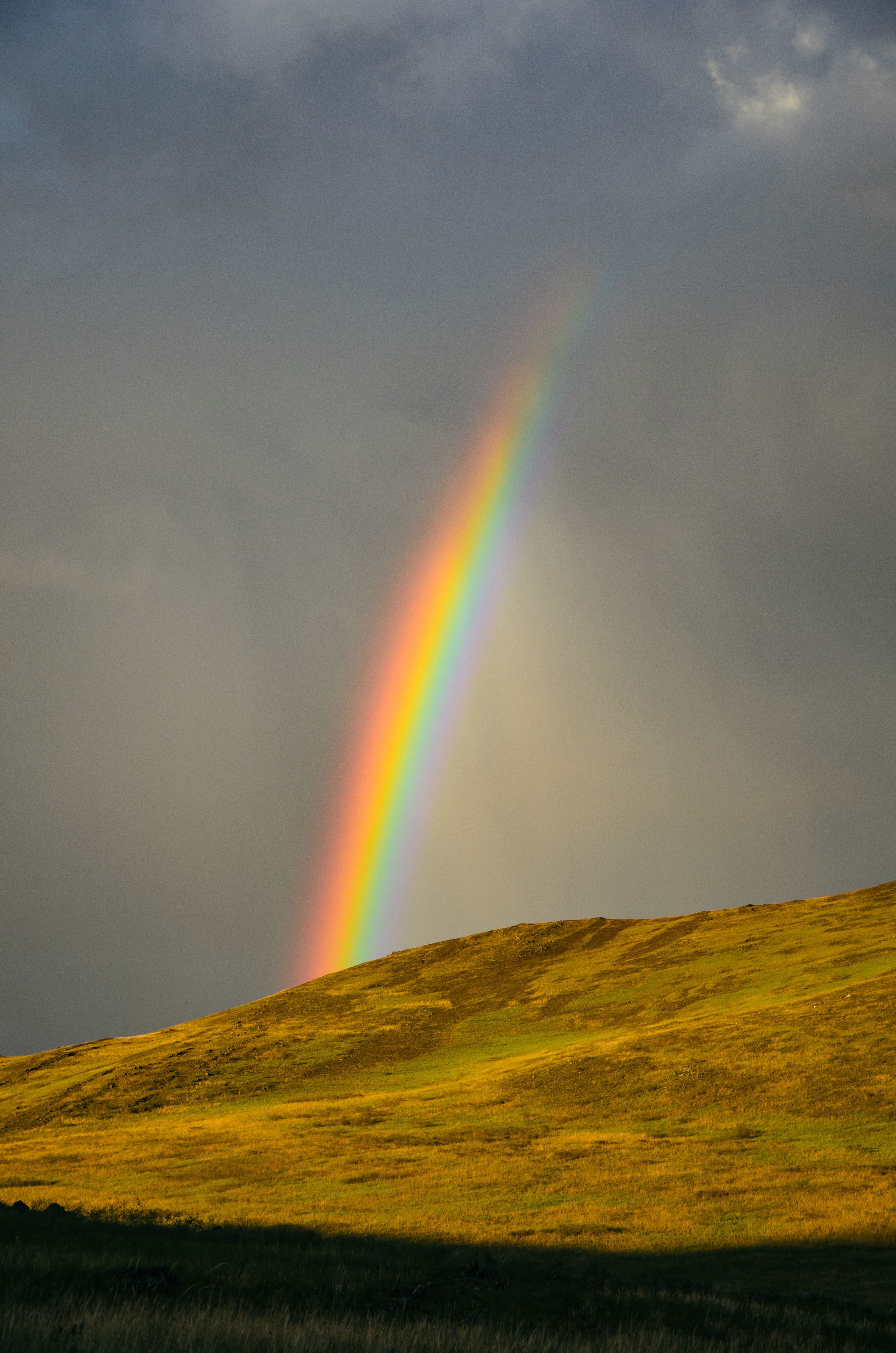 Rainbow in cloudy sky at sunset · Free Stock Photo