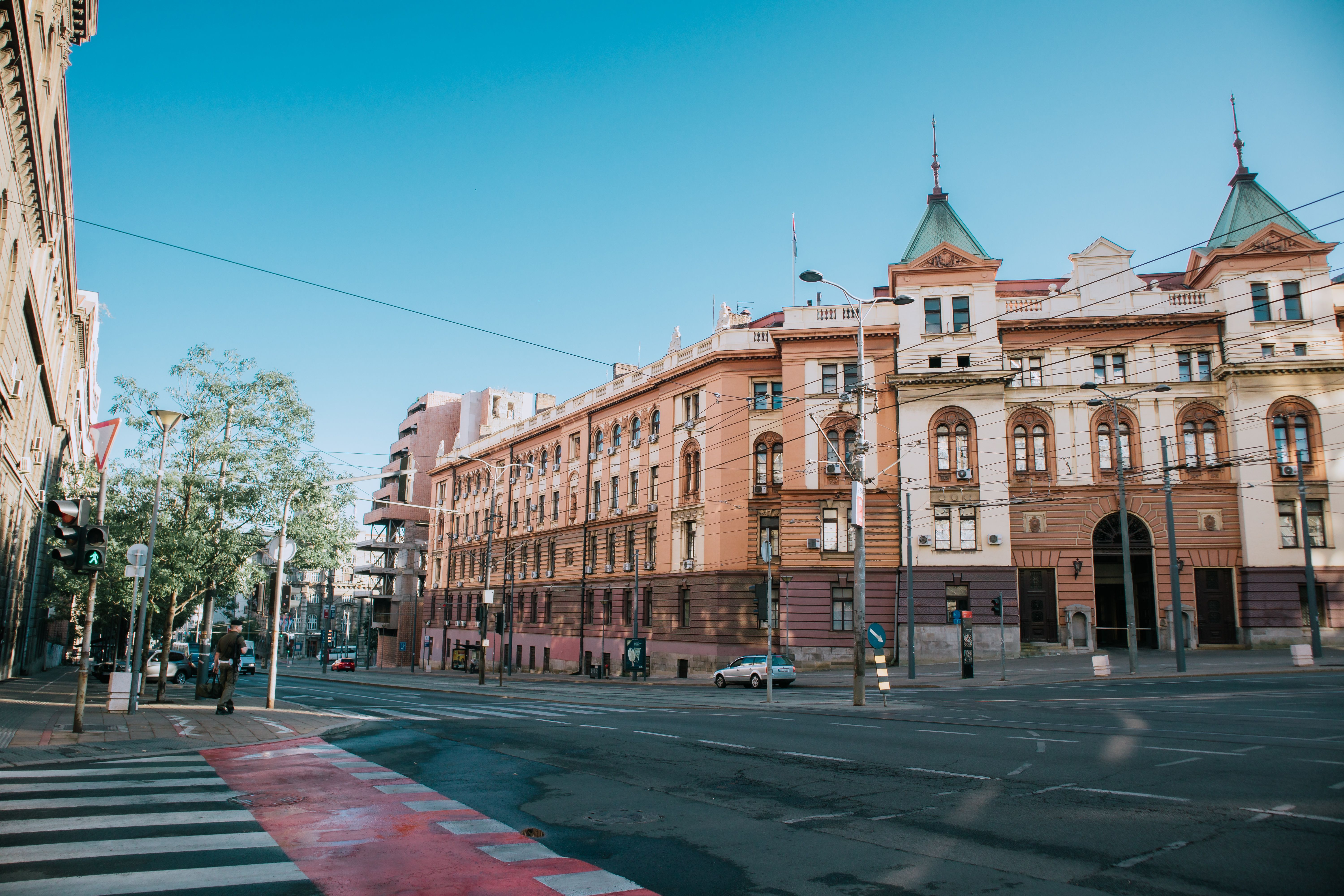 Historic European City Street Scene under Clear Blue Sky · Free Stock Photo
