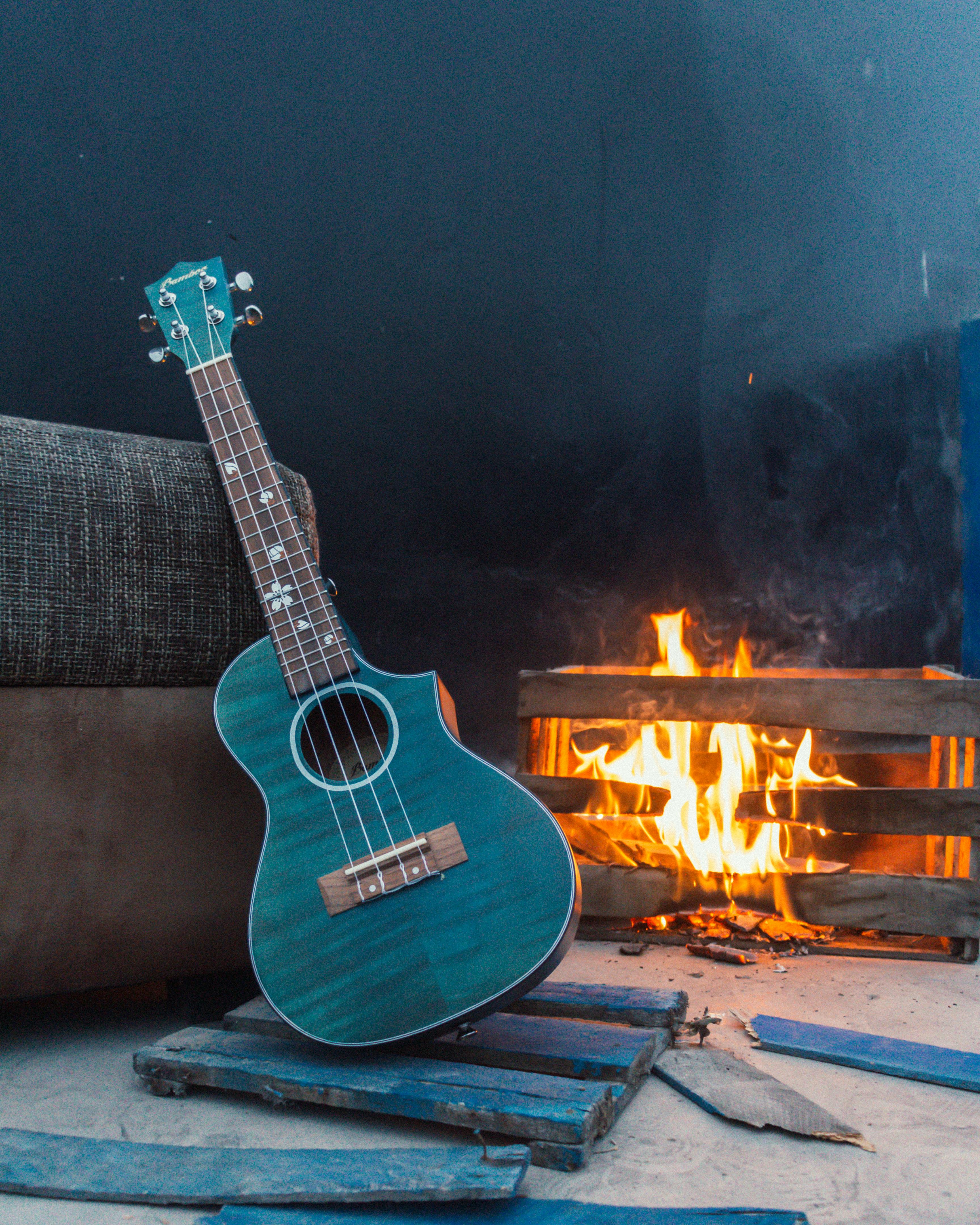 Stylish Ukulele by Cozy Indoor Fireplace · Free Stock Photo