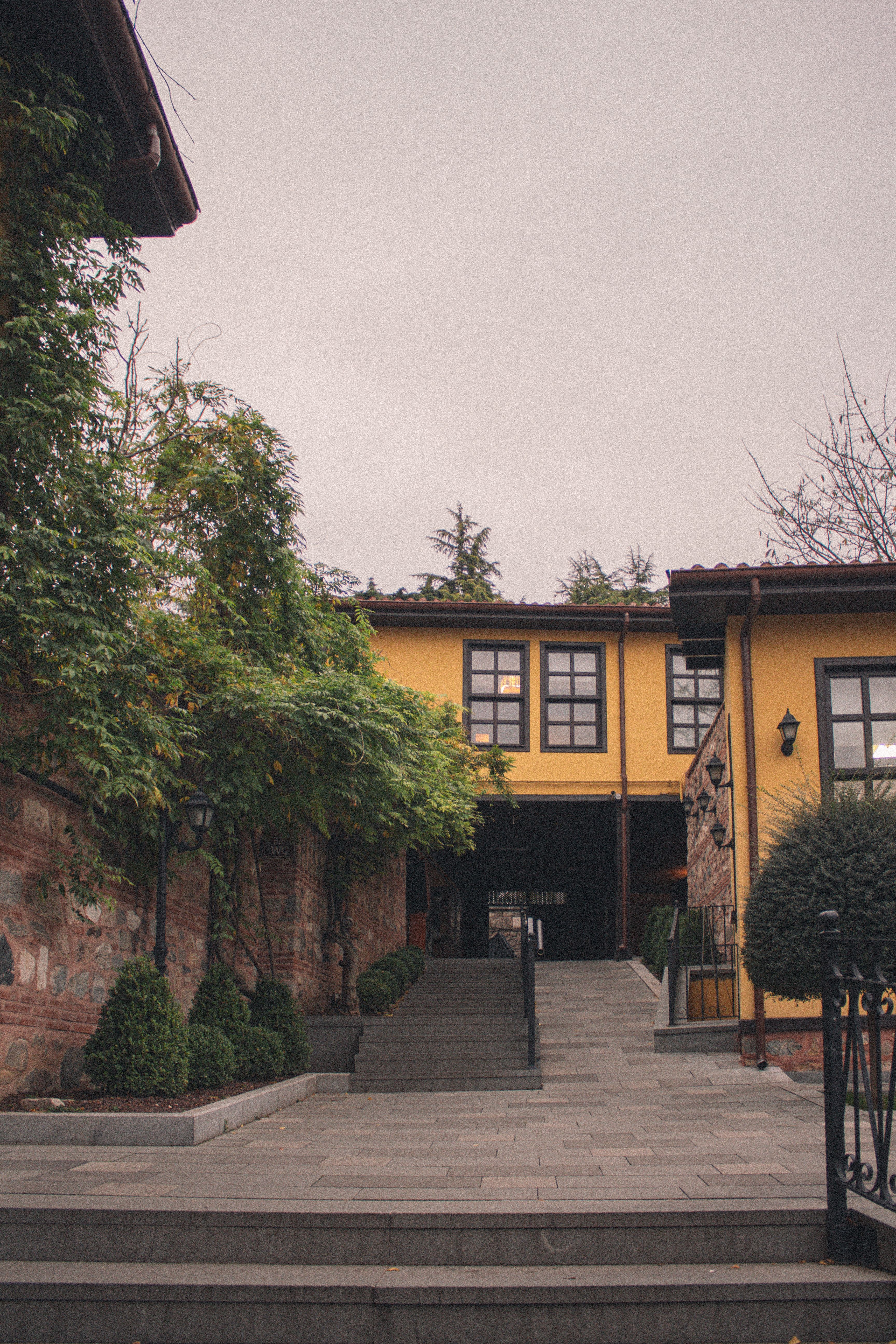 Charming Courtyard with Rustic Yellow Building · Free Stock Photo