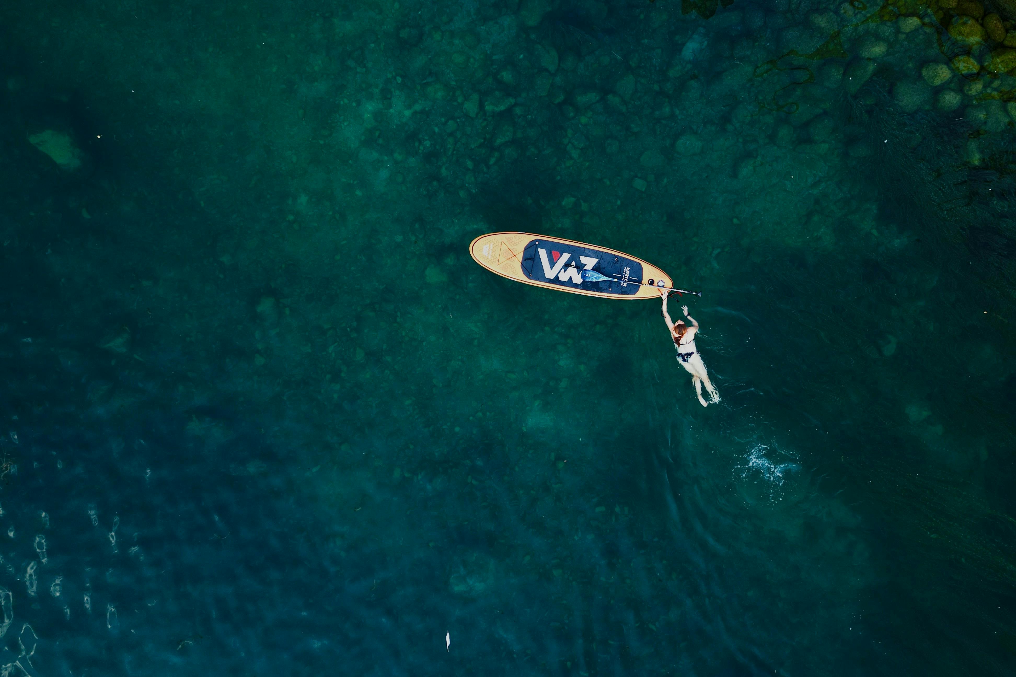 Aerial View of Paddleboarder in Clear Blue Water · Free Stock Photo