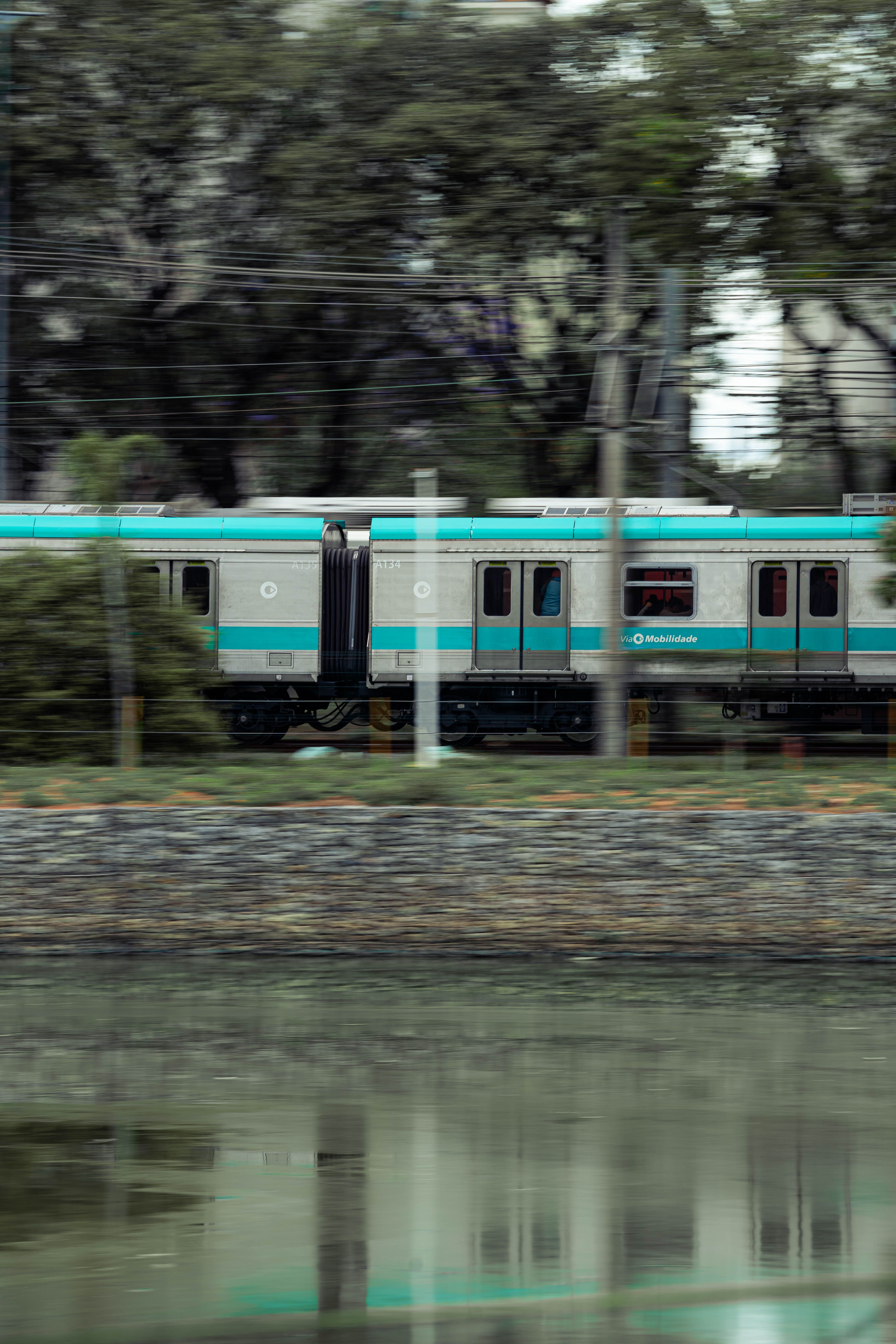 High-Speed Train Passing Reflective Water · Free Stock Photo
