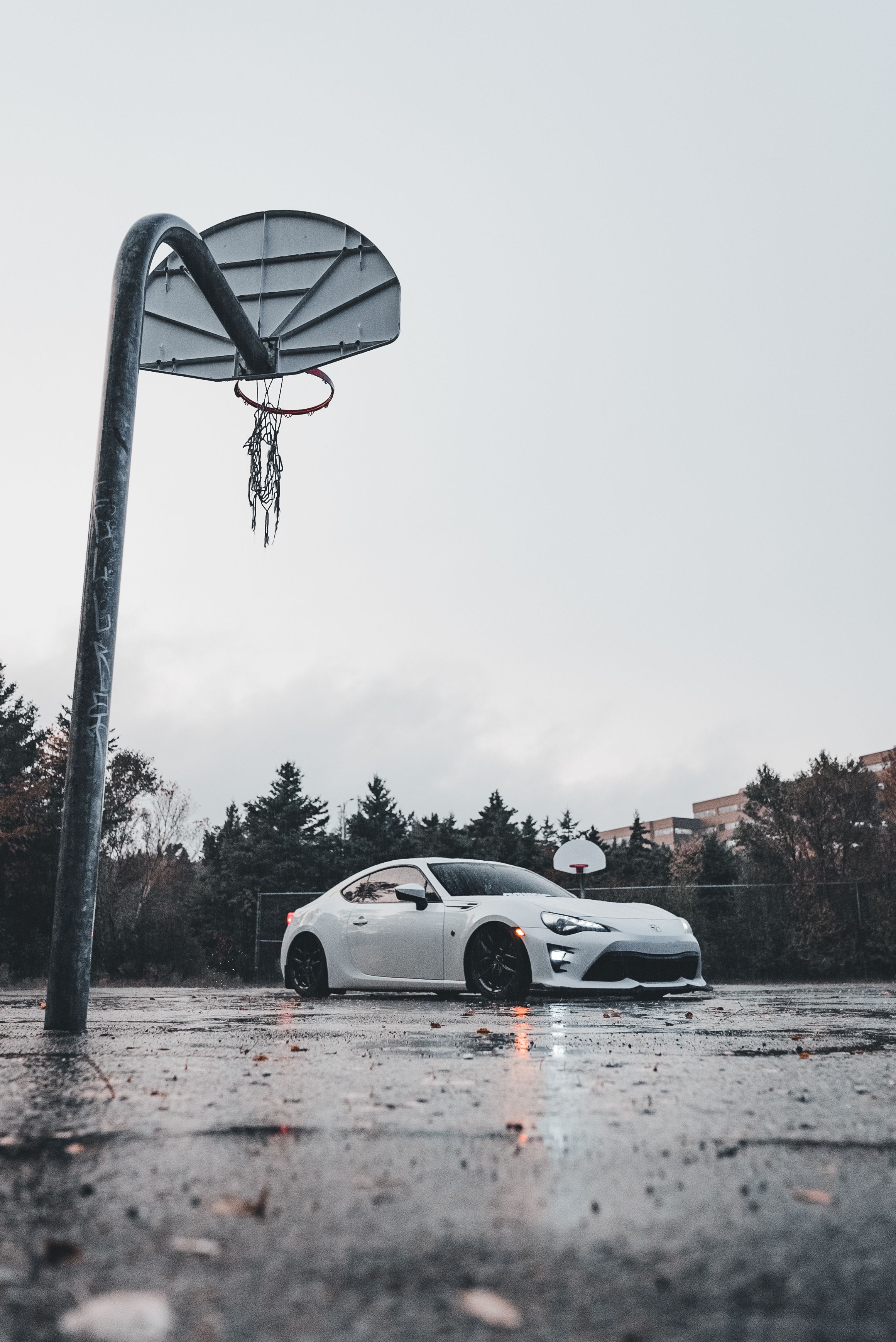 Sleek White Car on Urban Basketball Court · Free Stock Photo