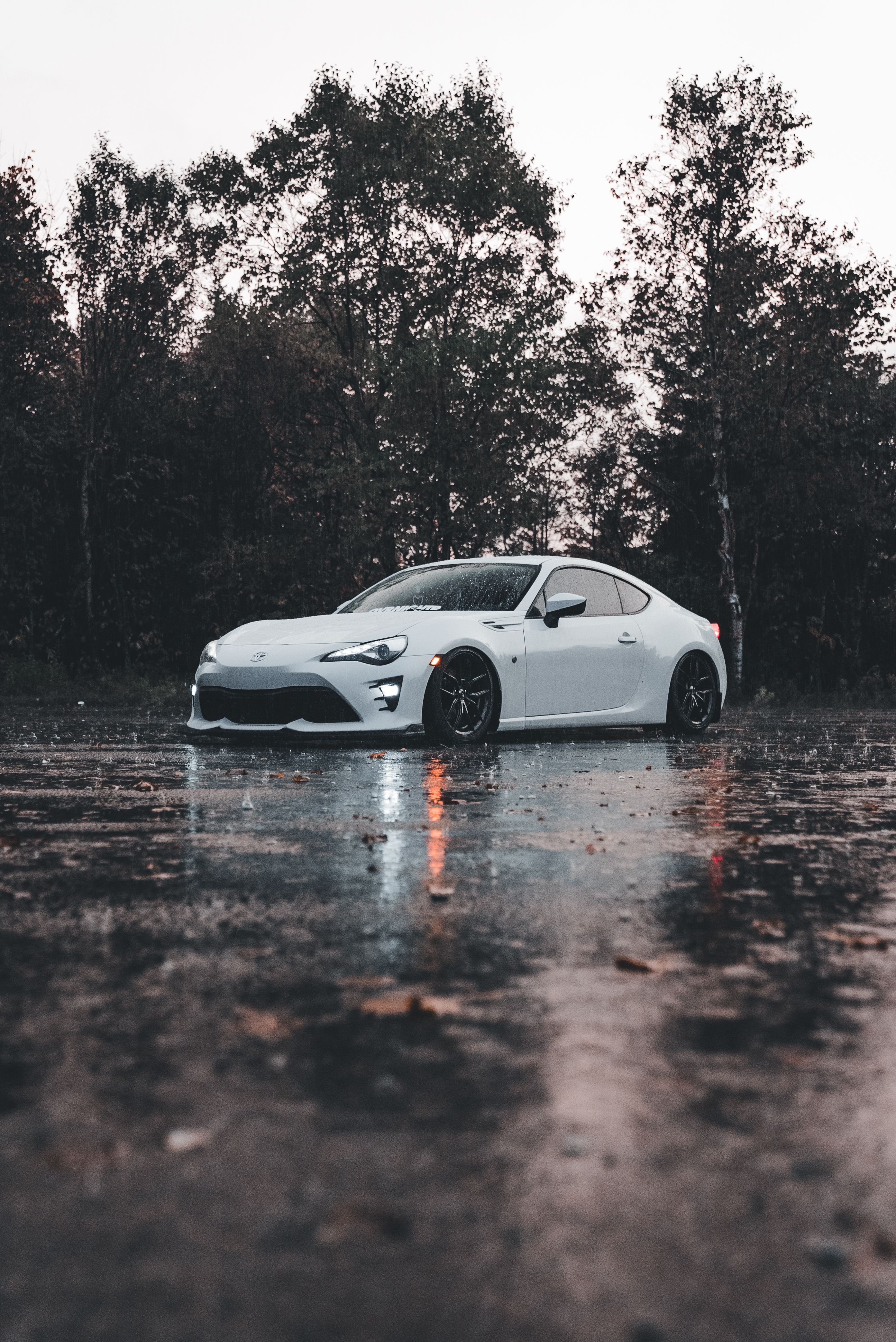 Sleek White Sports Car on a Rainy Day · Free Stock Photo