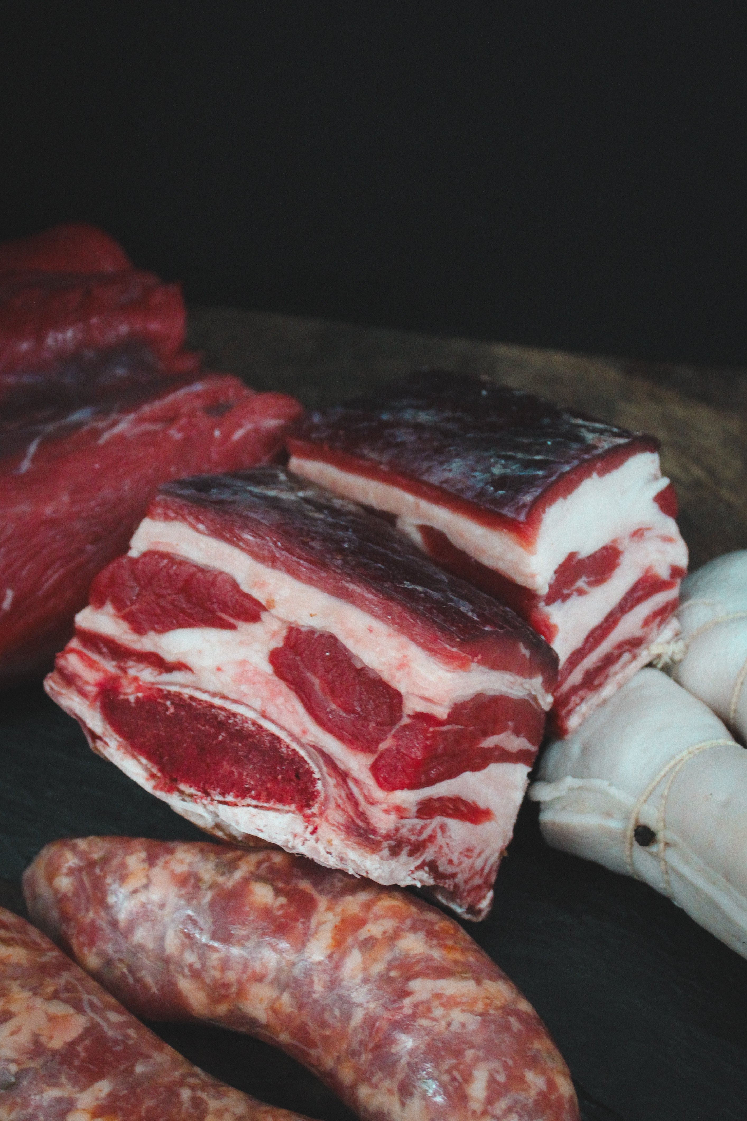 Assorted Cuts of Raw Meat on Dark Background · Free Stock Photo