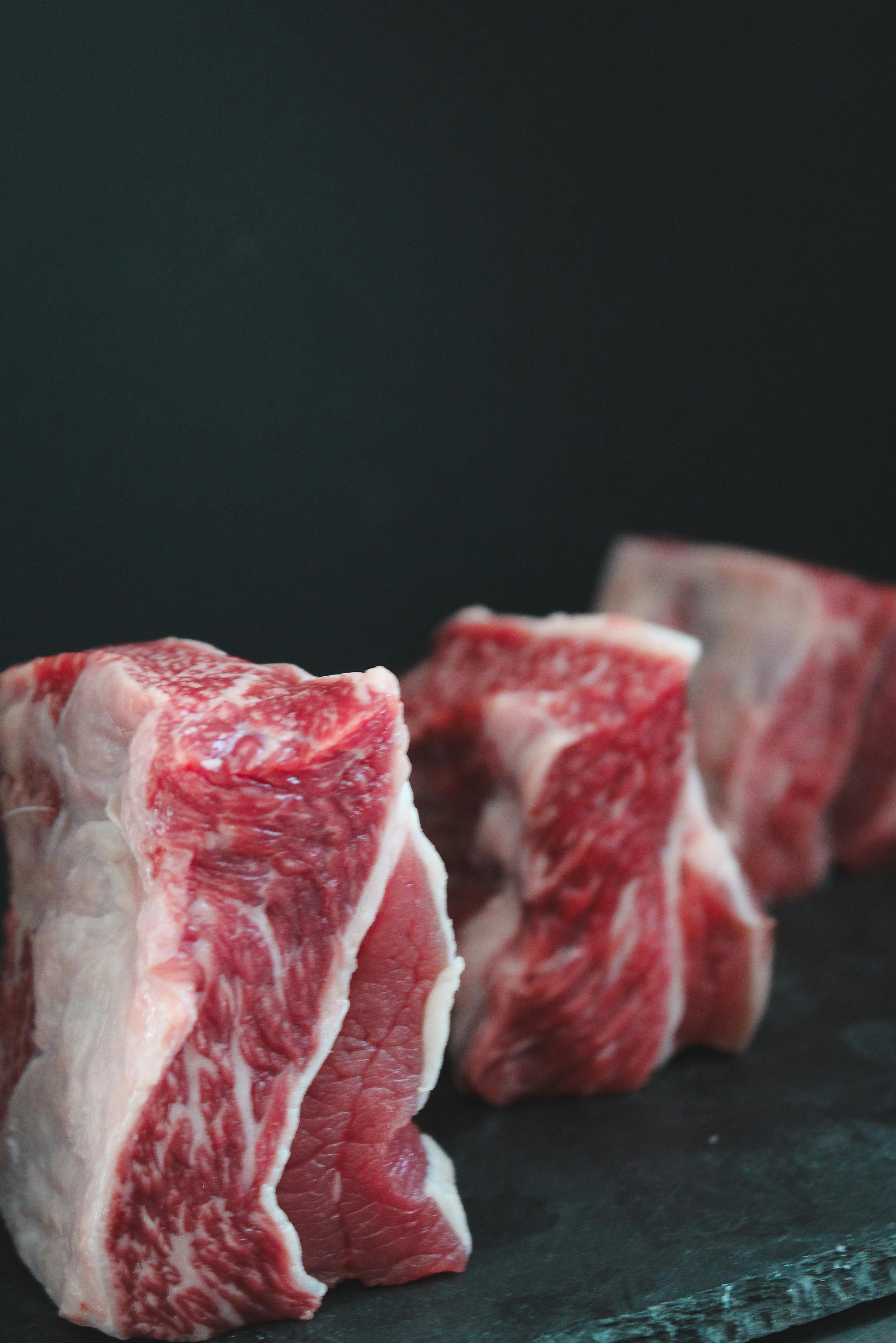 High-Quality Raw Beef Cuts on Dark Surface · Free Stock Photo