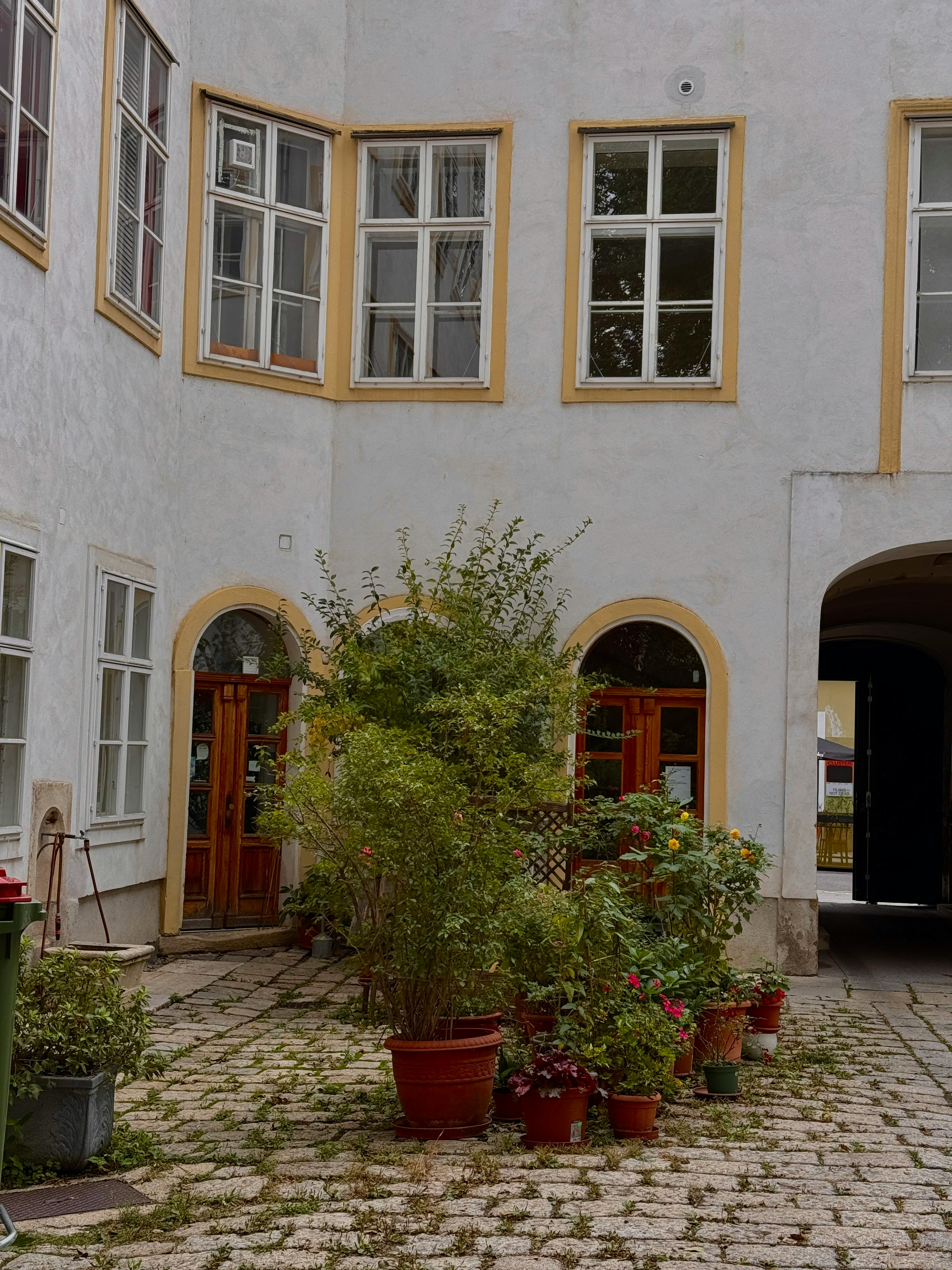 Charming European Courtyard with Potted Plants · Free Stock Photo