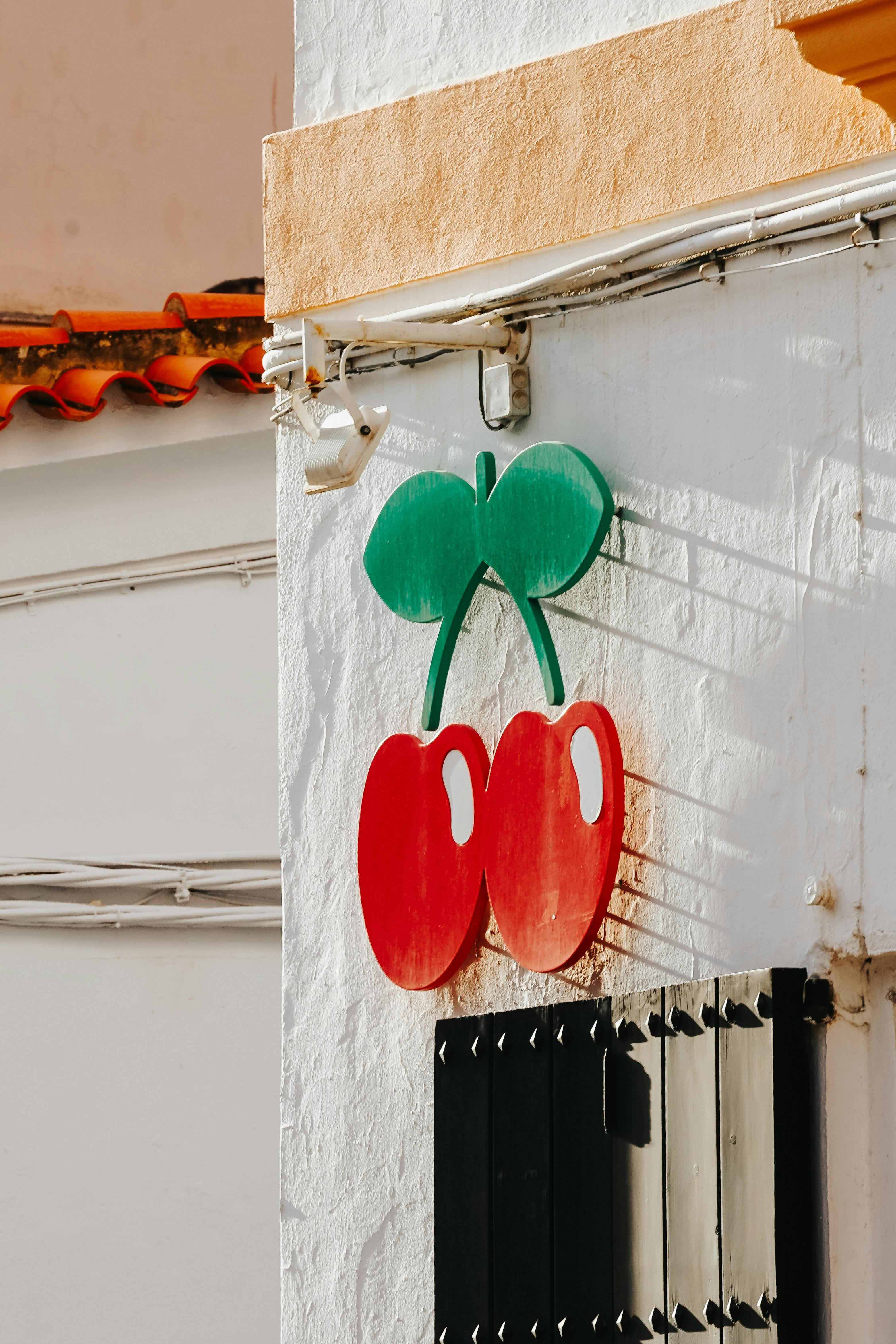 Colorful Cherry Sign on White Wall Exterior · Free Stock Photo