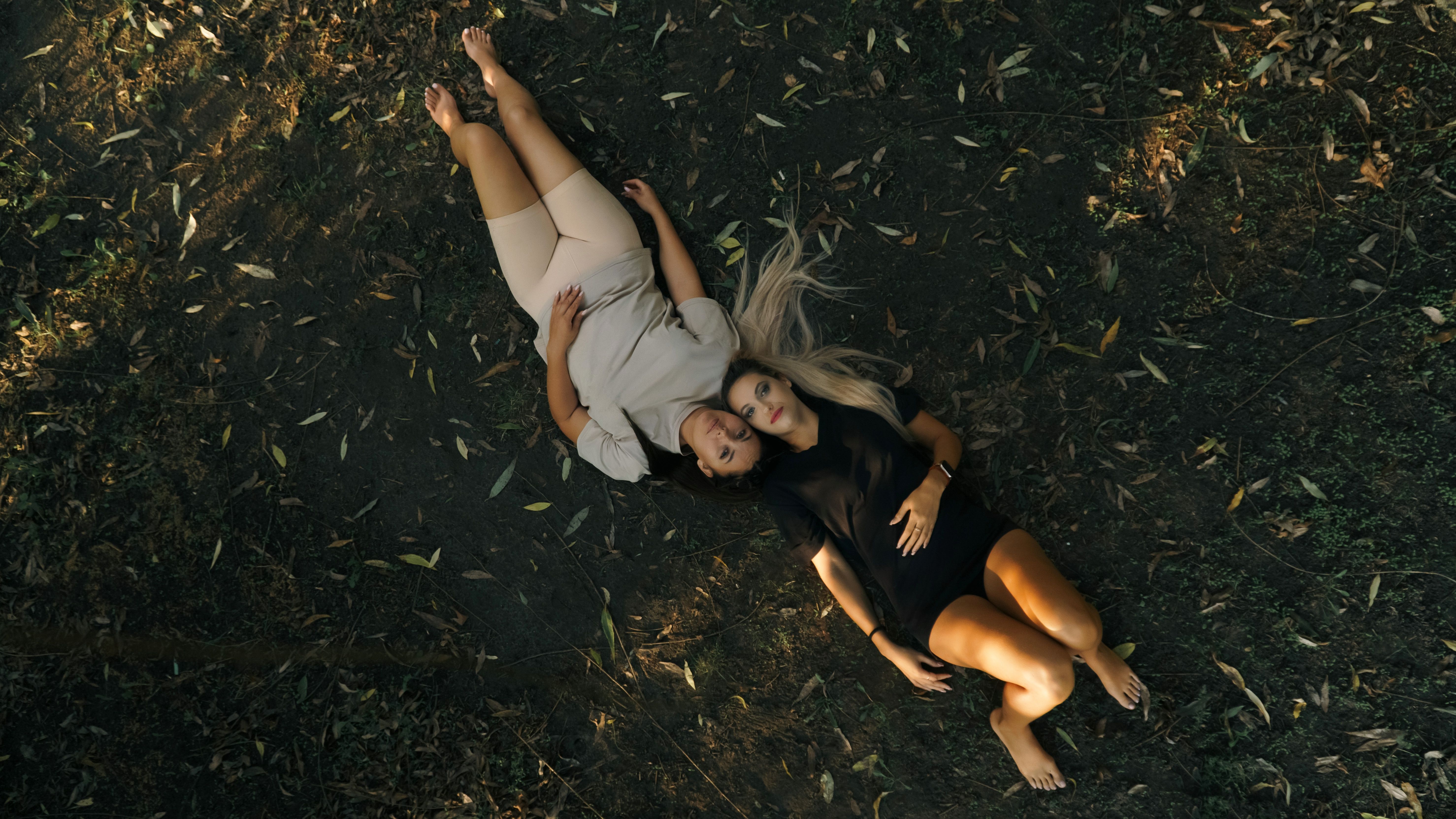 Two Women Lying on Forest Ground Relaxing · Free Stock Photo