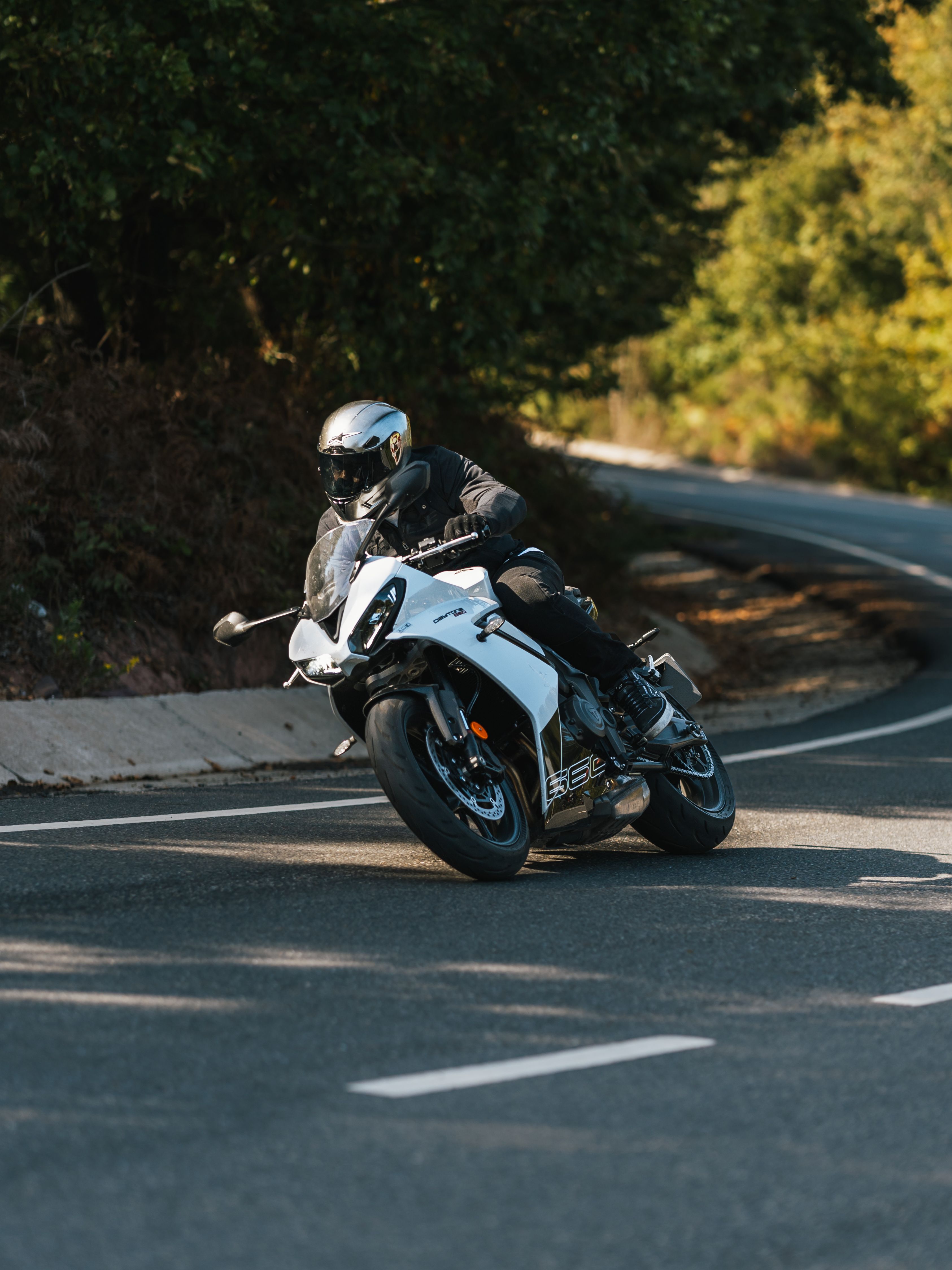 Motorcyclist expertly maneuvering sharp turn · Free Stock Photo