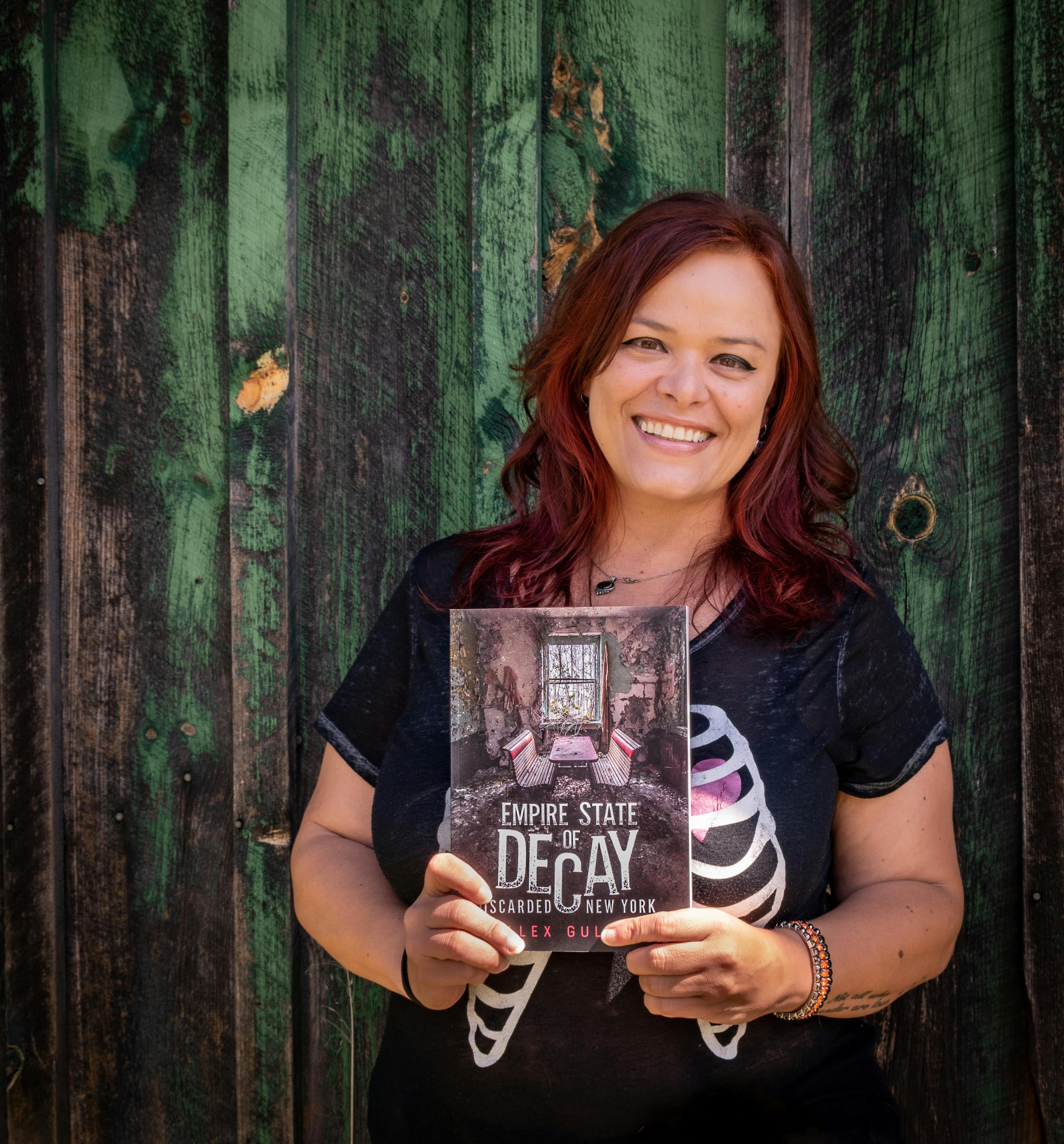 Woman Holding 'Empire State of Decay' Book Outdoors · Free Stock Photo