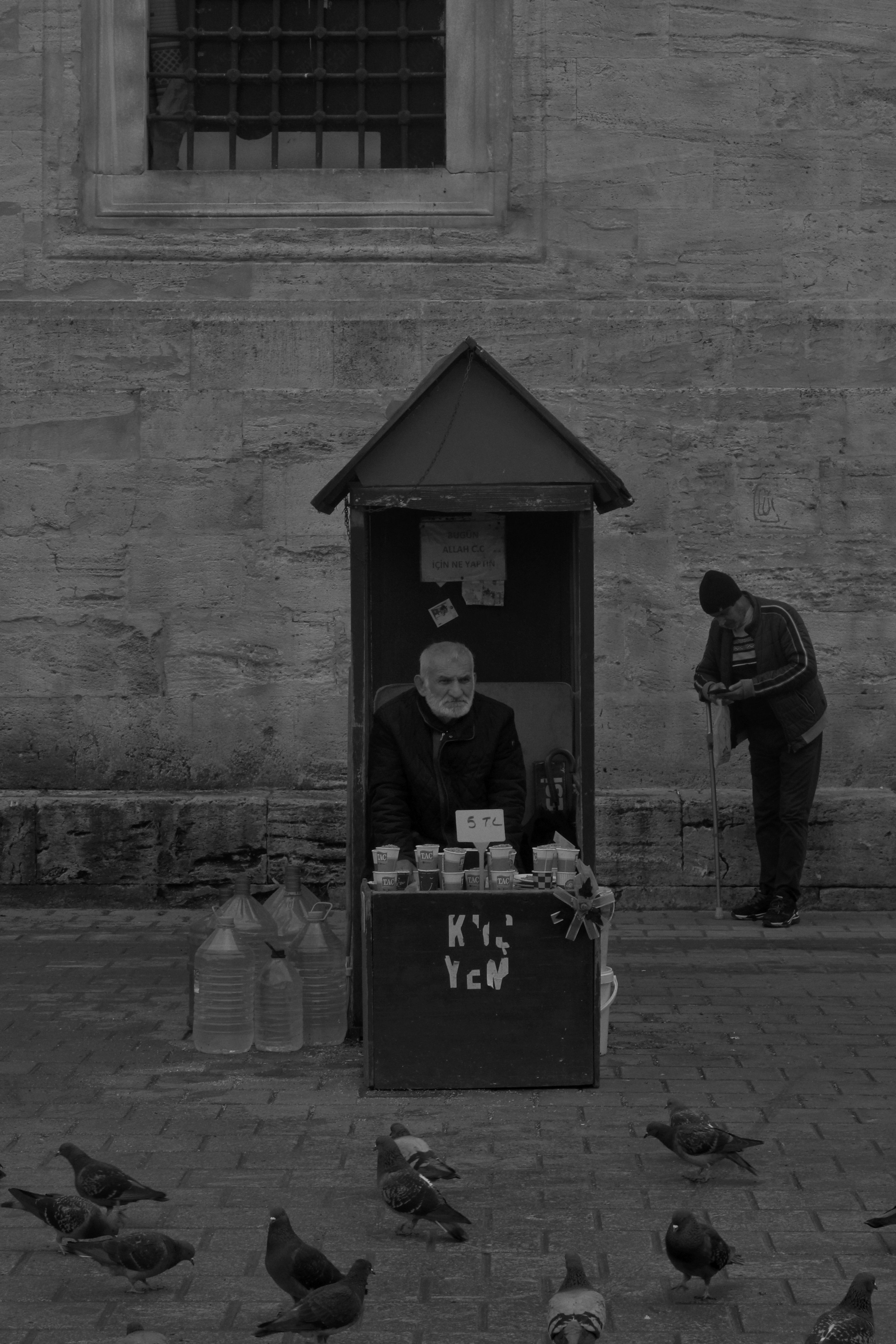 Street Vendor Selling Goods in Urban Setting · Free Stock Photo