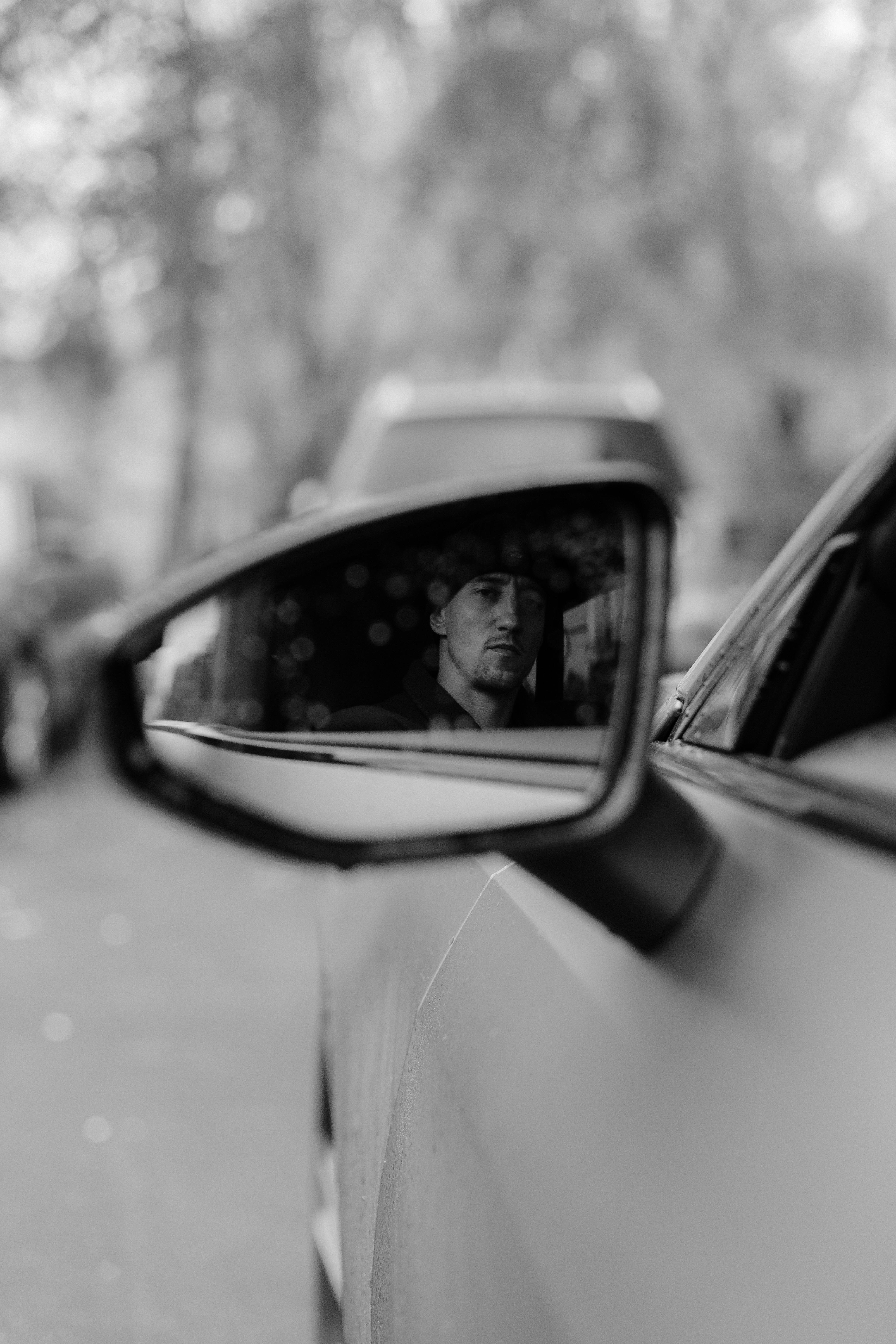 Reflective Urban Portrait in Car Rearview Mirror · Free Stock Photo