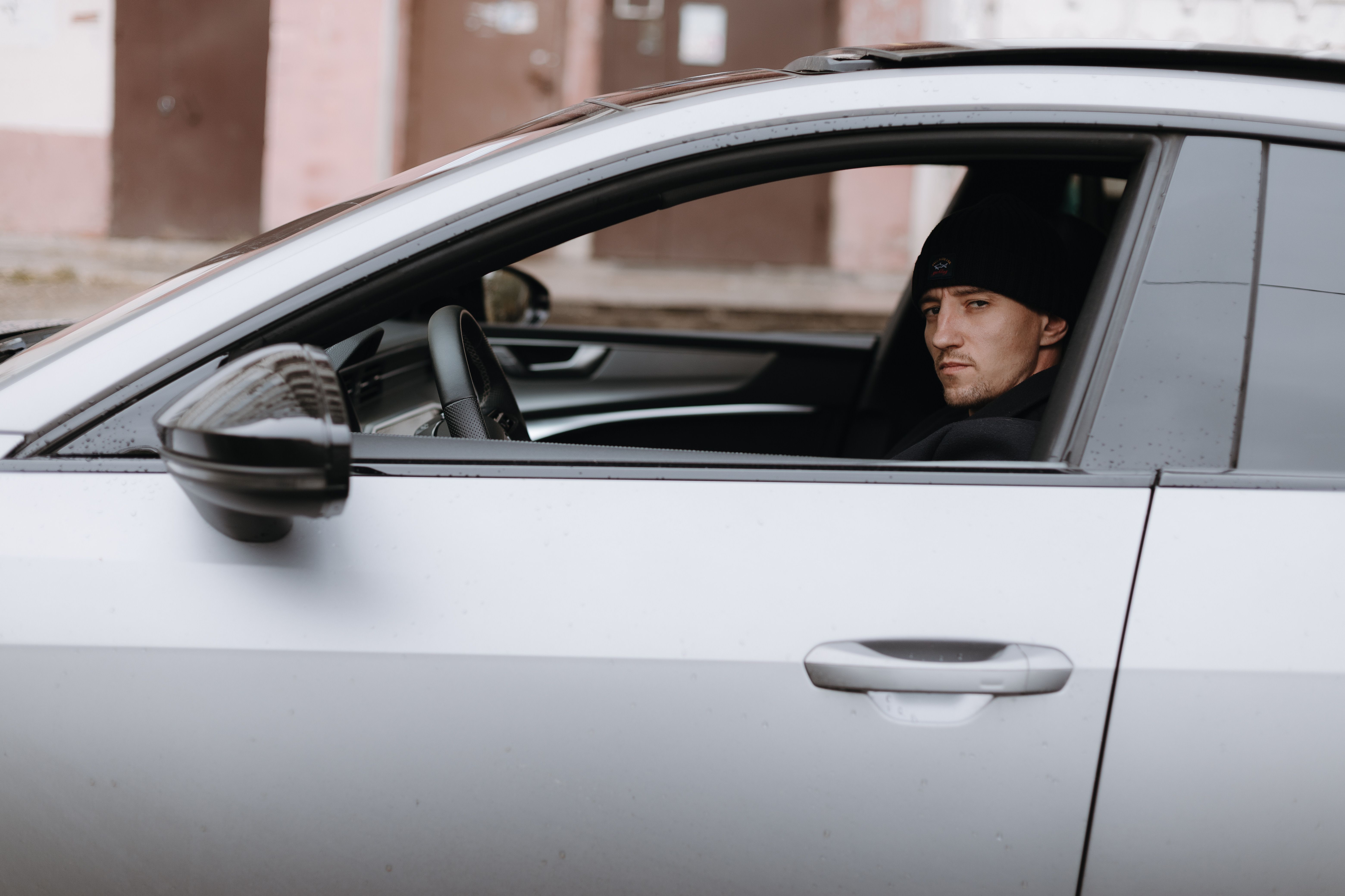 Casual Man Sitting in Car on Overcast Day · Free Stock Photo