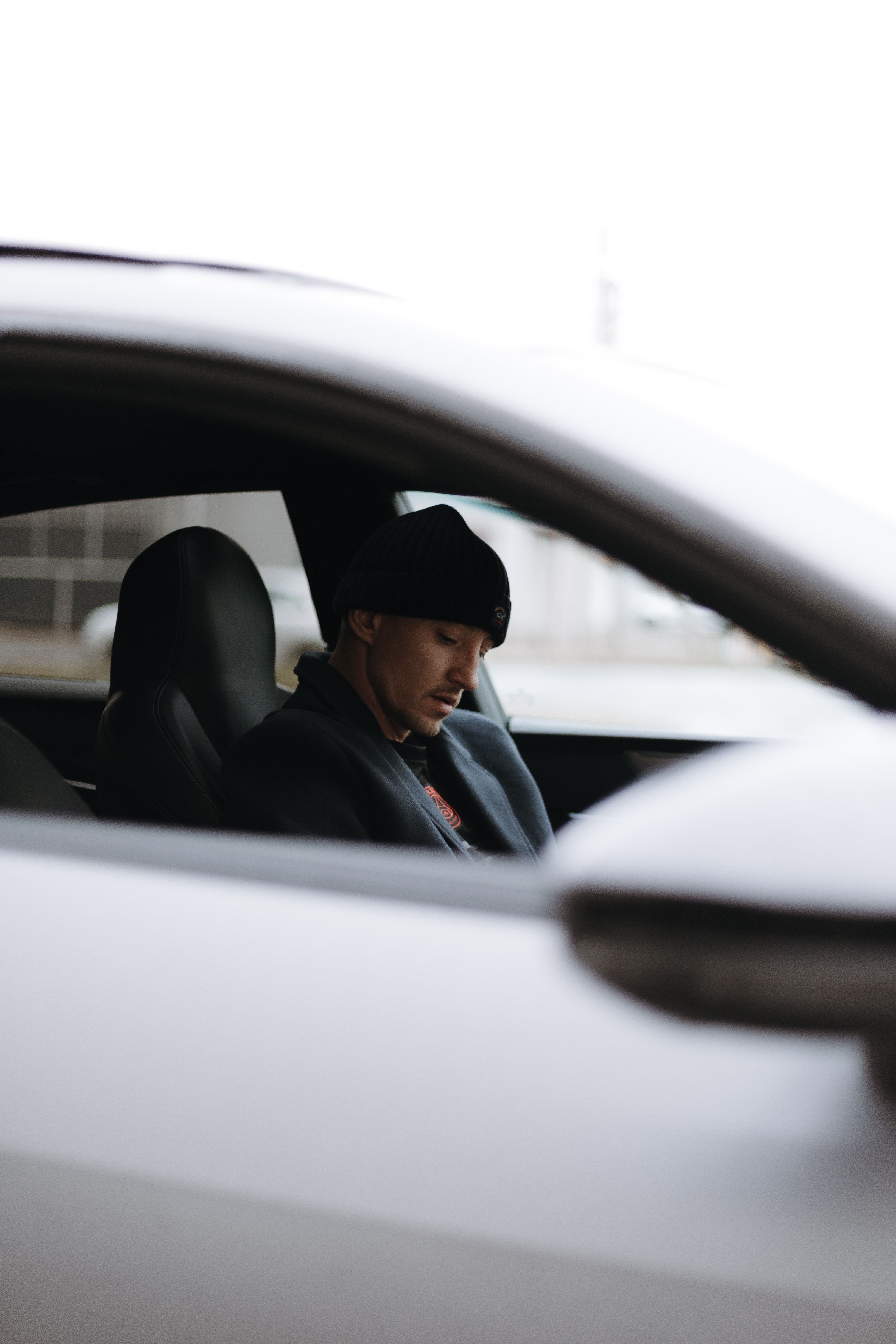 Young Man Sitting in Car During Overcast Day · Free Stock Photo