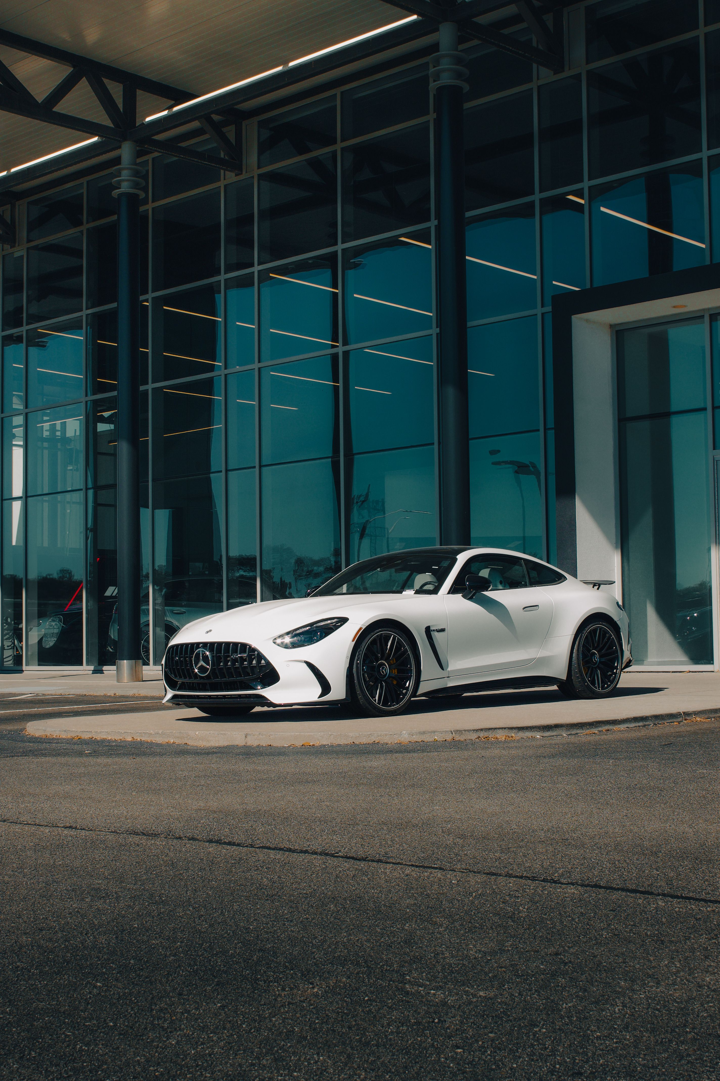 Sleek White Mercedes-Benz Parked by Glass Showroom · Free Stock Photo