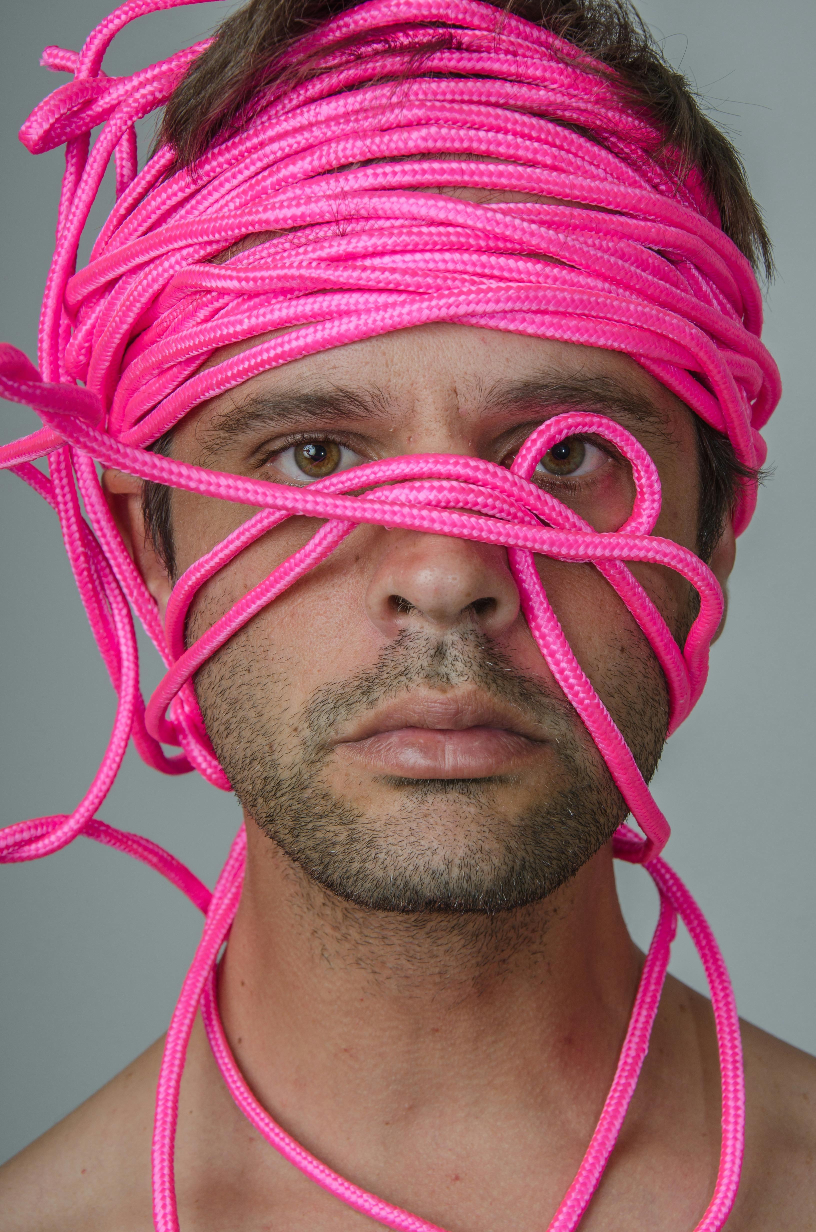 Man Entangled in Vibrant Pink Rope Portrait · Free Stock Photo