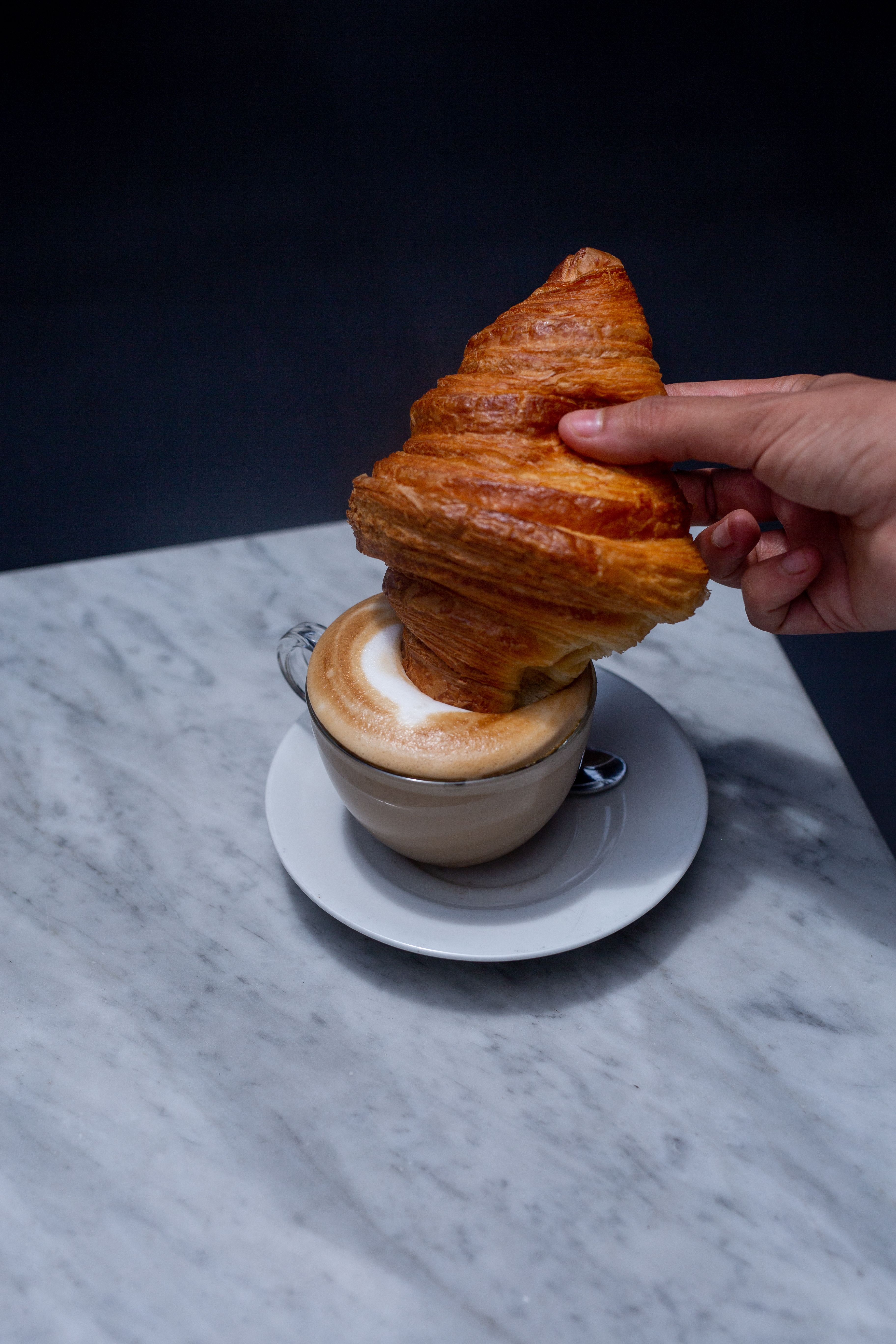 Delicious Croissant Dipping into Cappuccino · Free Stock Photo