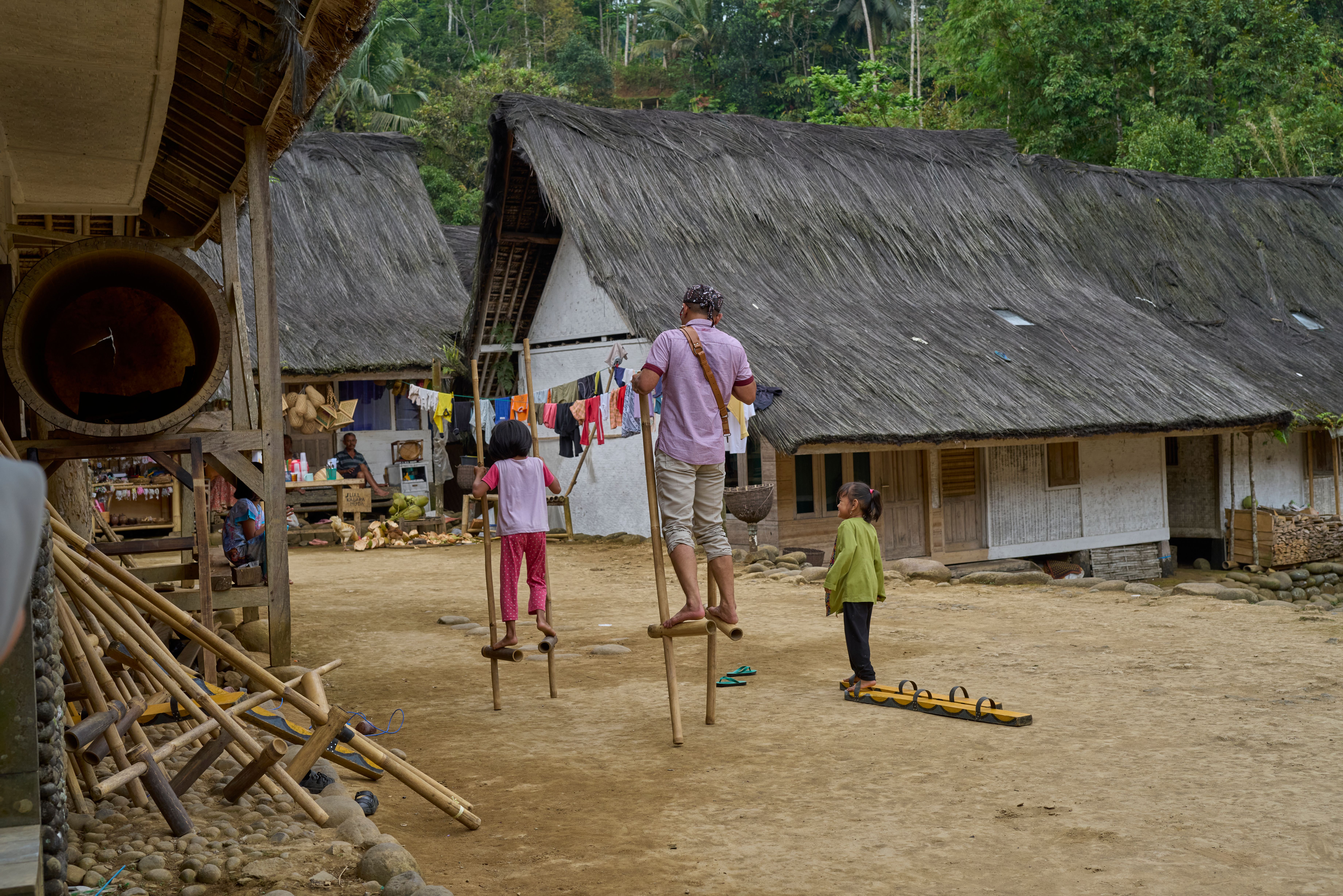 Traditional Village Scene with Children on Stilts · Free Stock Photo