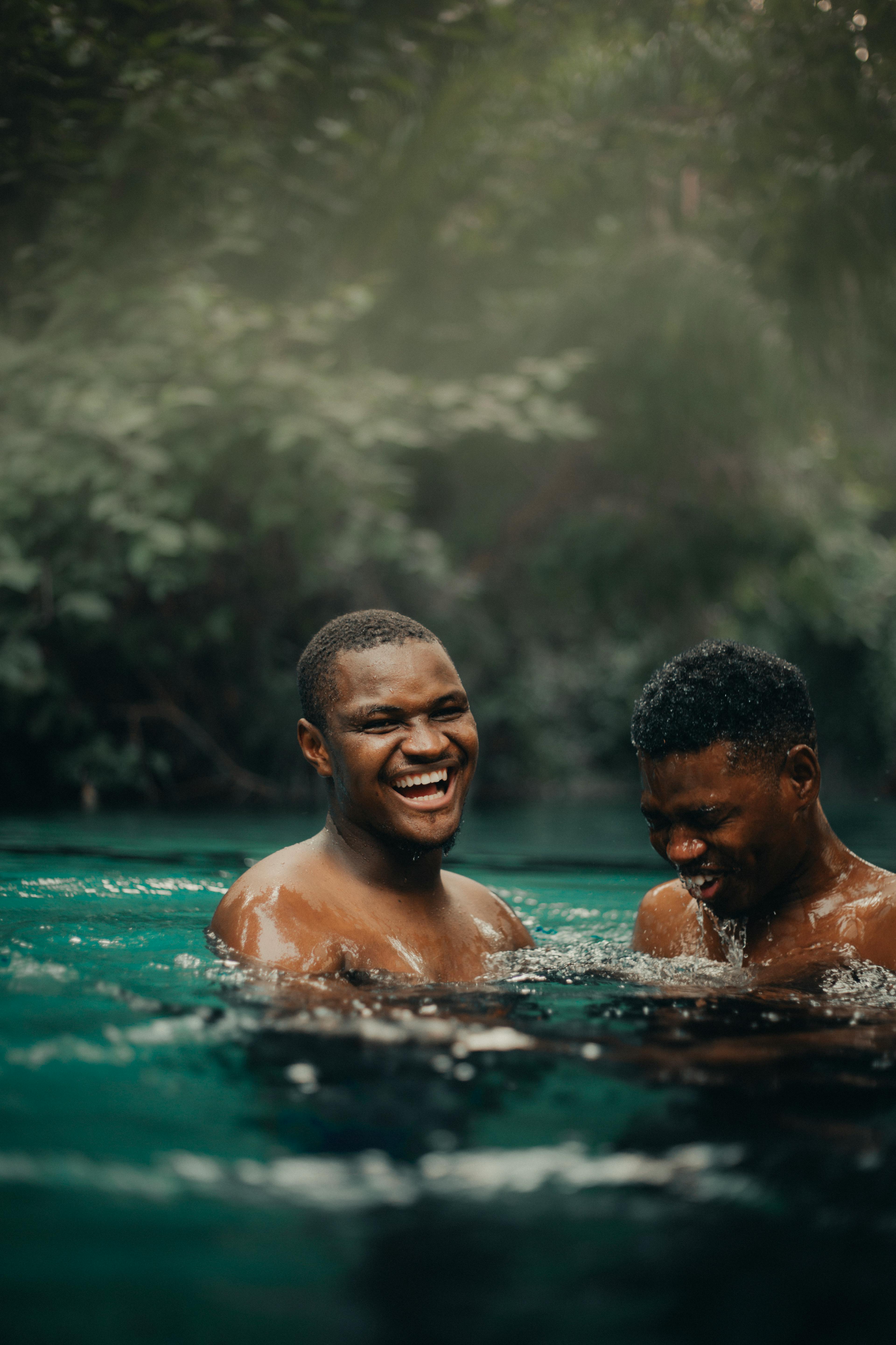 Joyful Friends Swimming in Natural Pool Outdoors · Free Stock Photo
