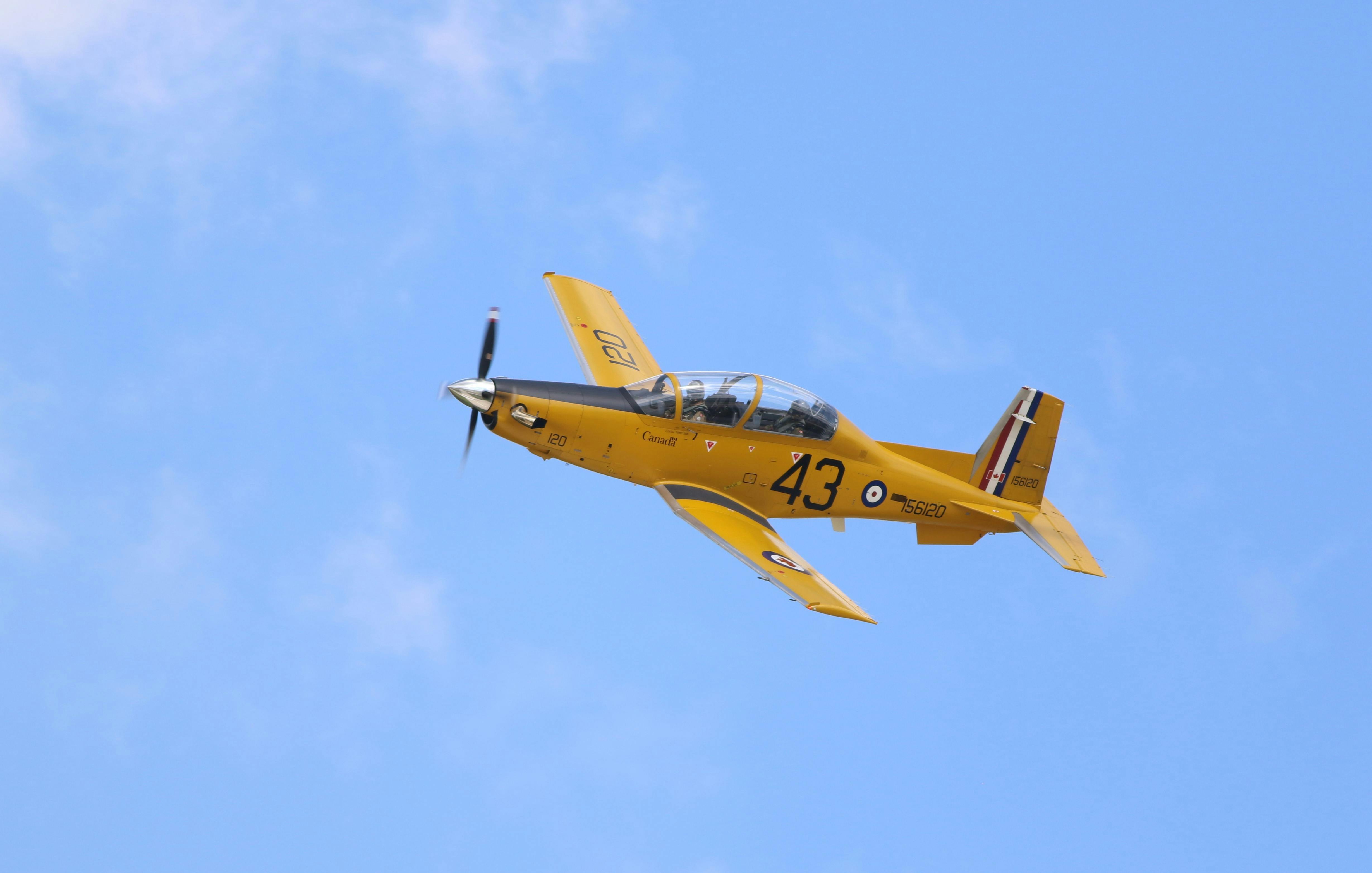 Yellow Training Aircraft Soaring in Clear Sky · Free Stock Photo