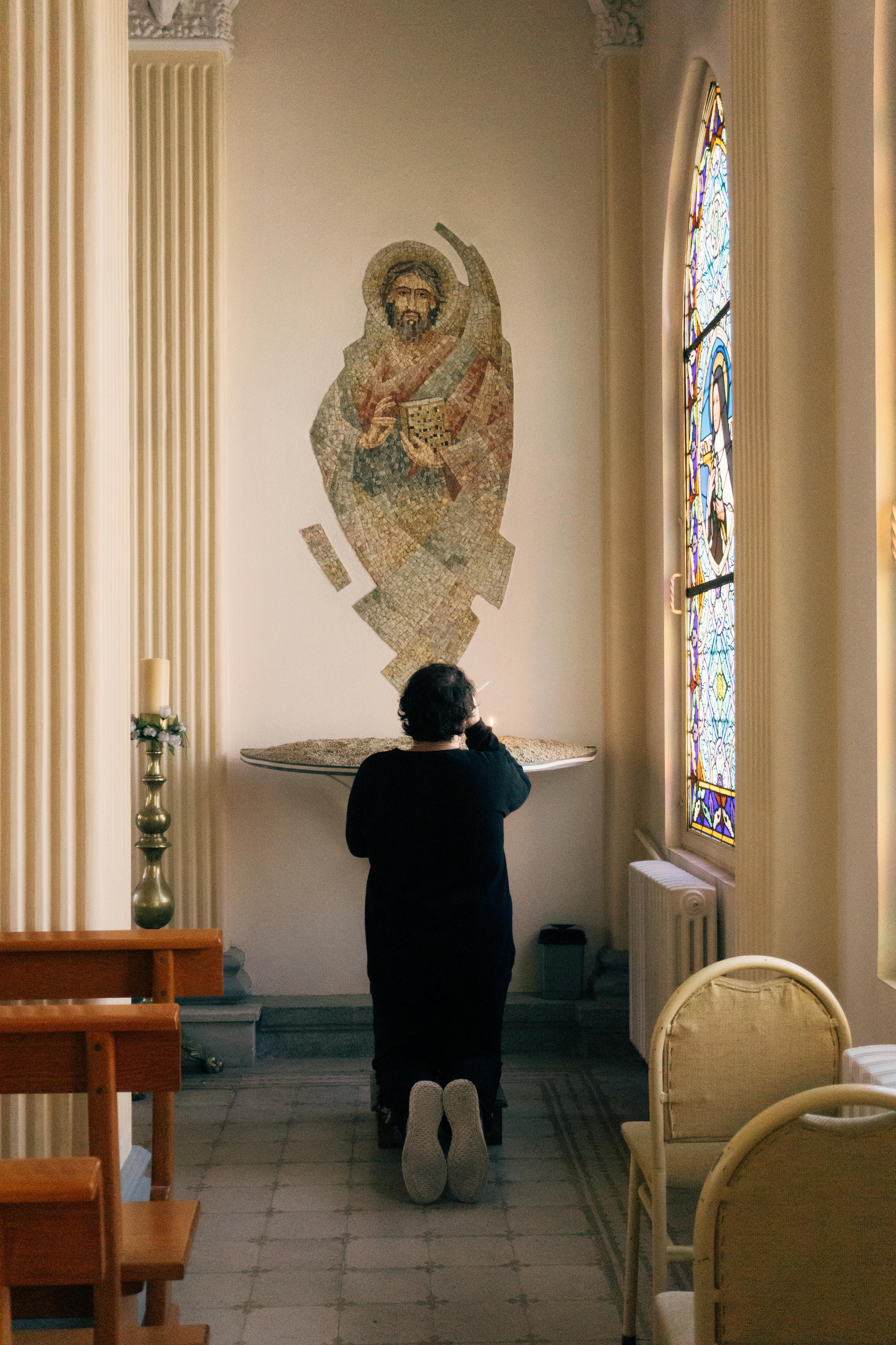 Persona Rezando En Una Iglesia Con Vidrieras · Foto de stock gratuita