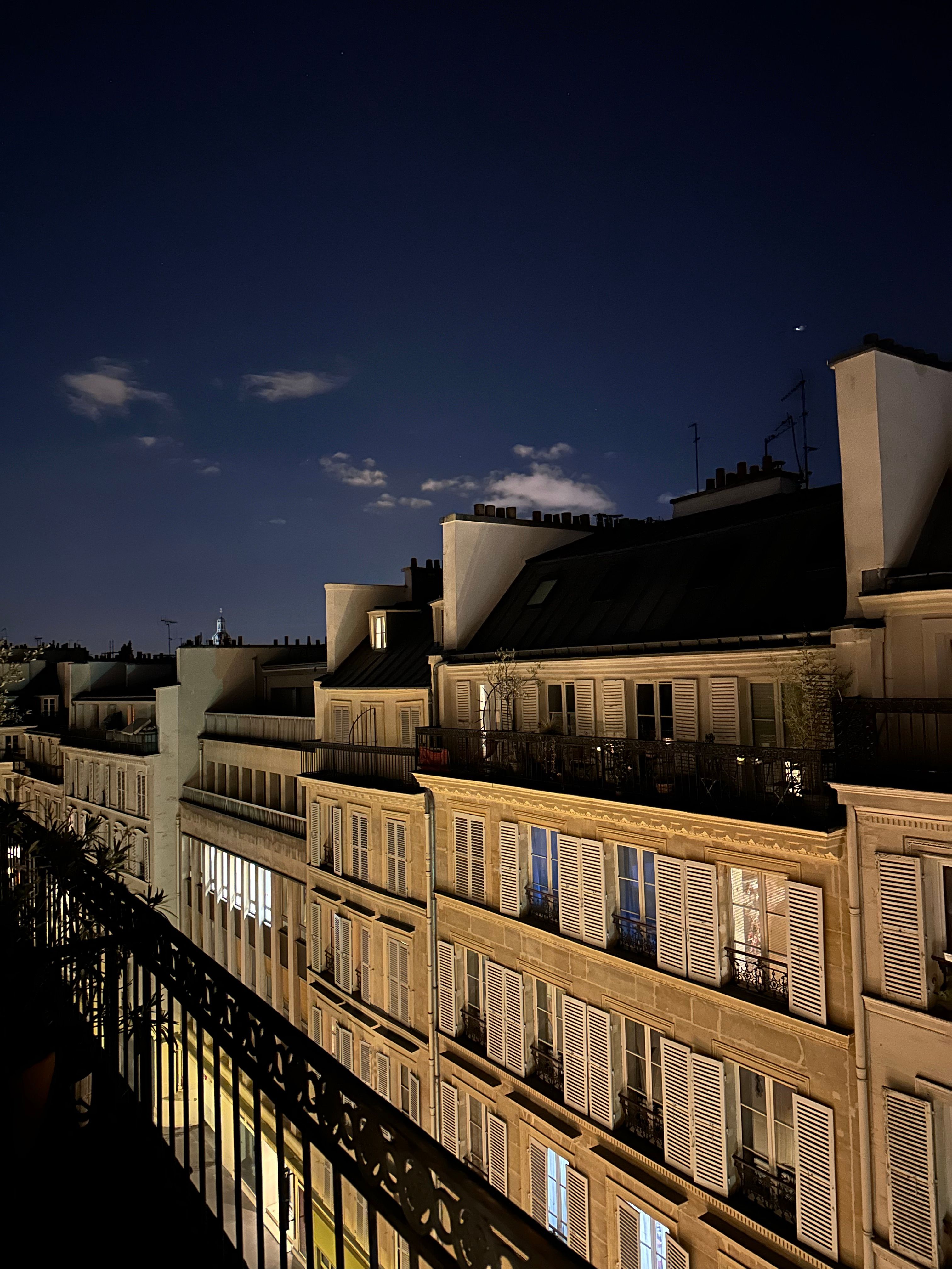 Nighttime View of Parisian Rooftops with Eiffel Tower · Free Stock Photo