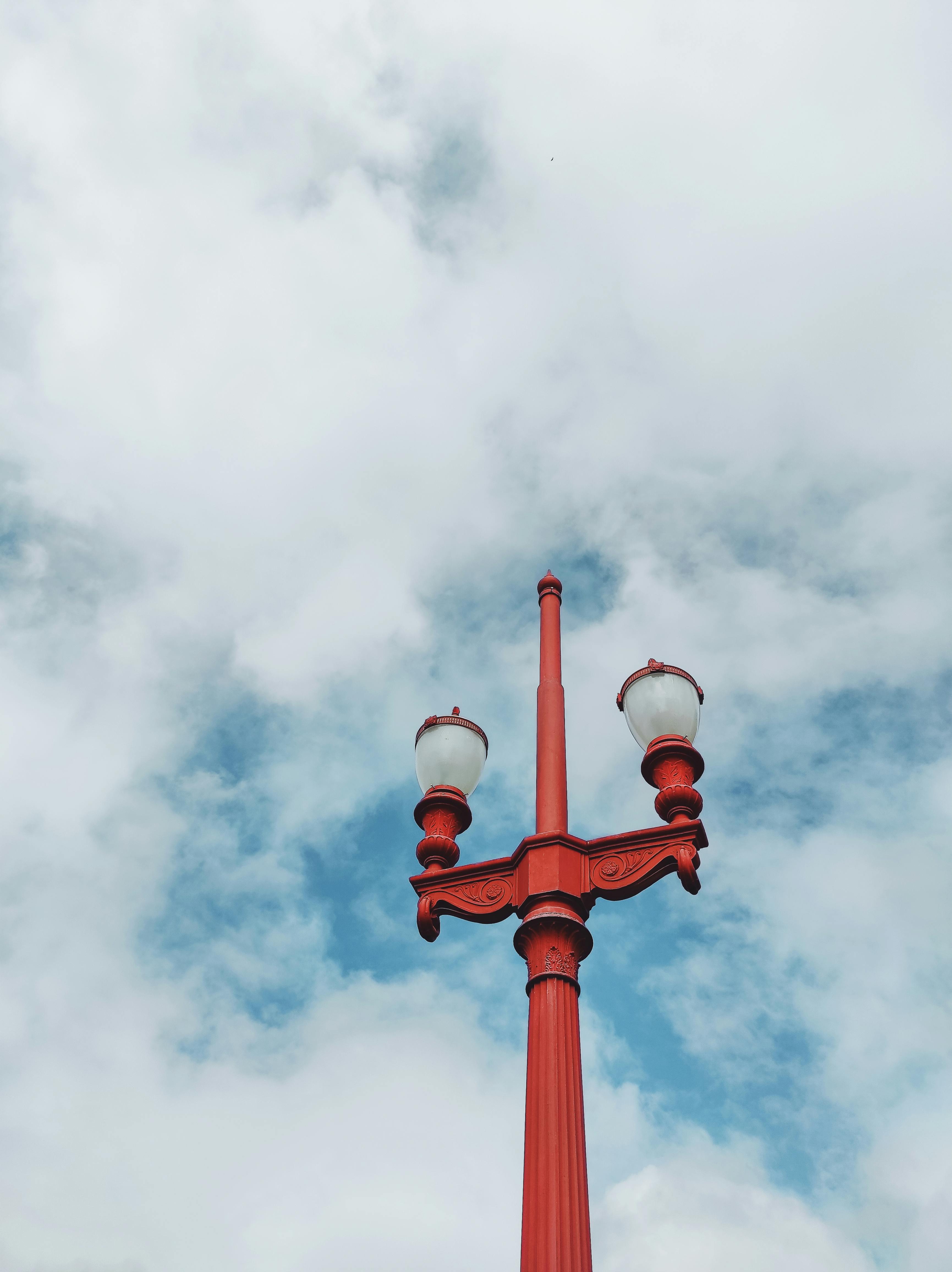 Vintage Red Lamp Post Against a Cloudy Sky · Free Stock Photo